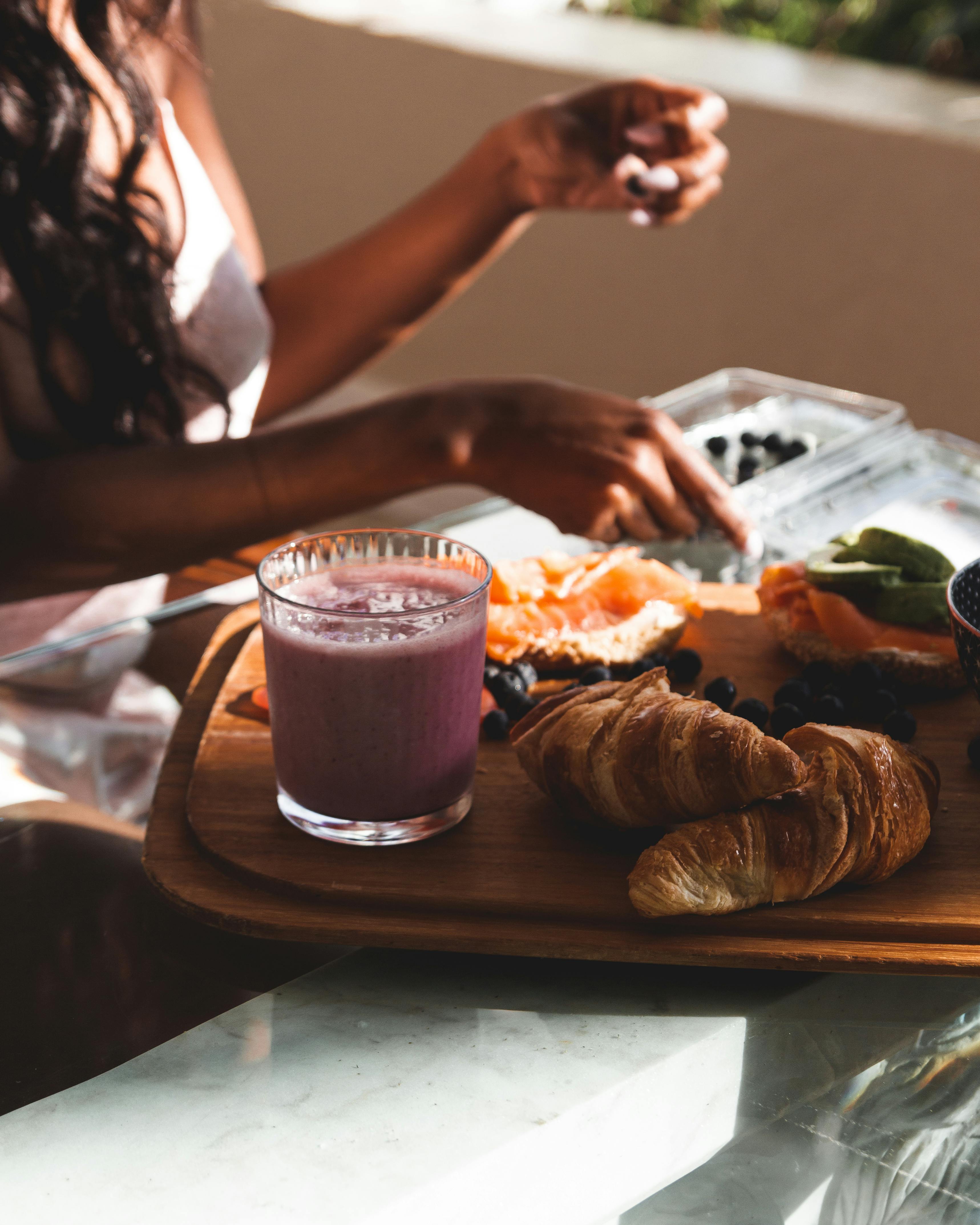 A Smiling Woman Eating Breakfast · Free Stock Photo