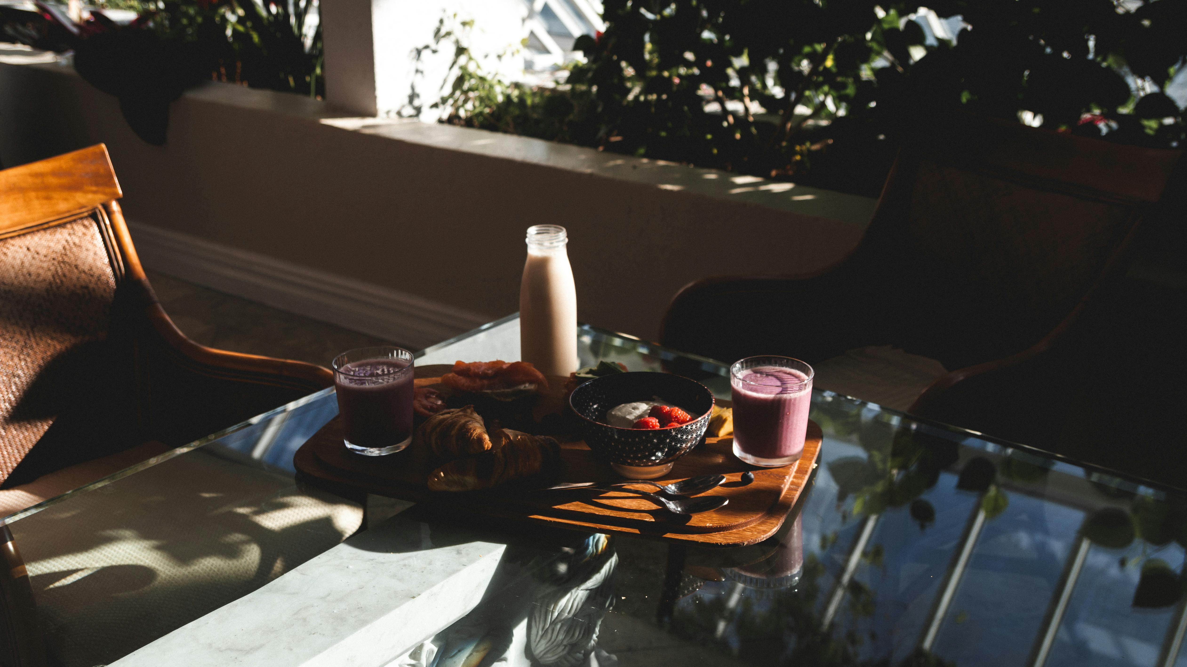 Breakfast and Drinks Standing on a Table on a Balcony · Free Stock Photo