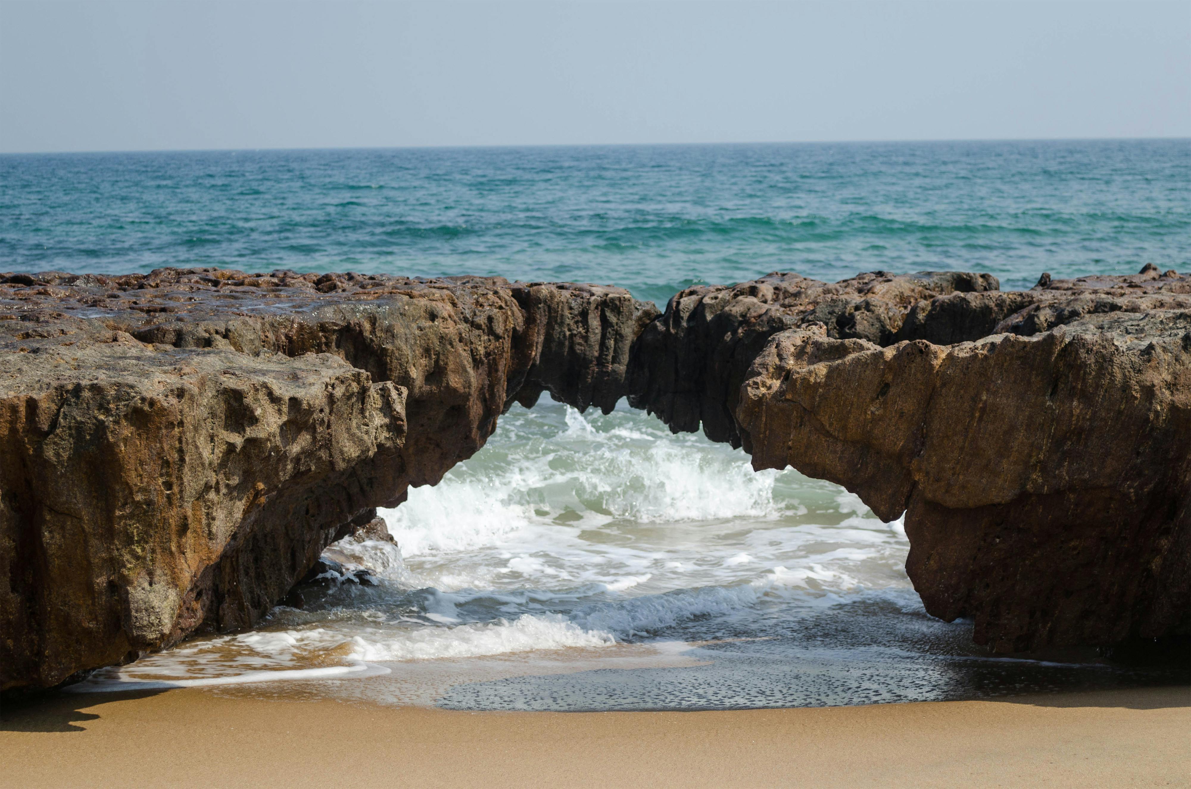 Rock Arch on Sand Seashore · Free Stock Photo