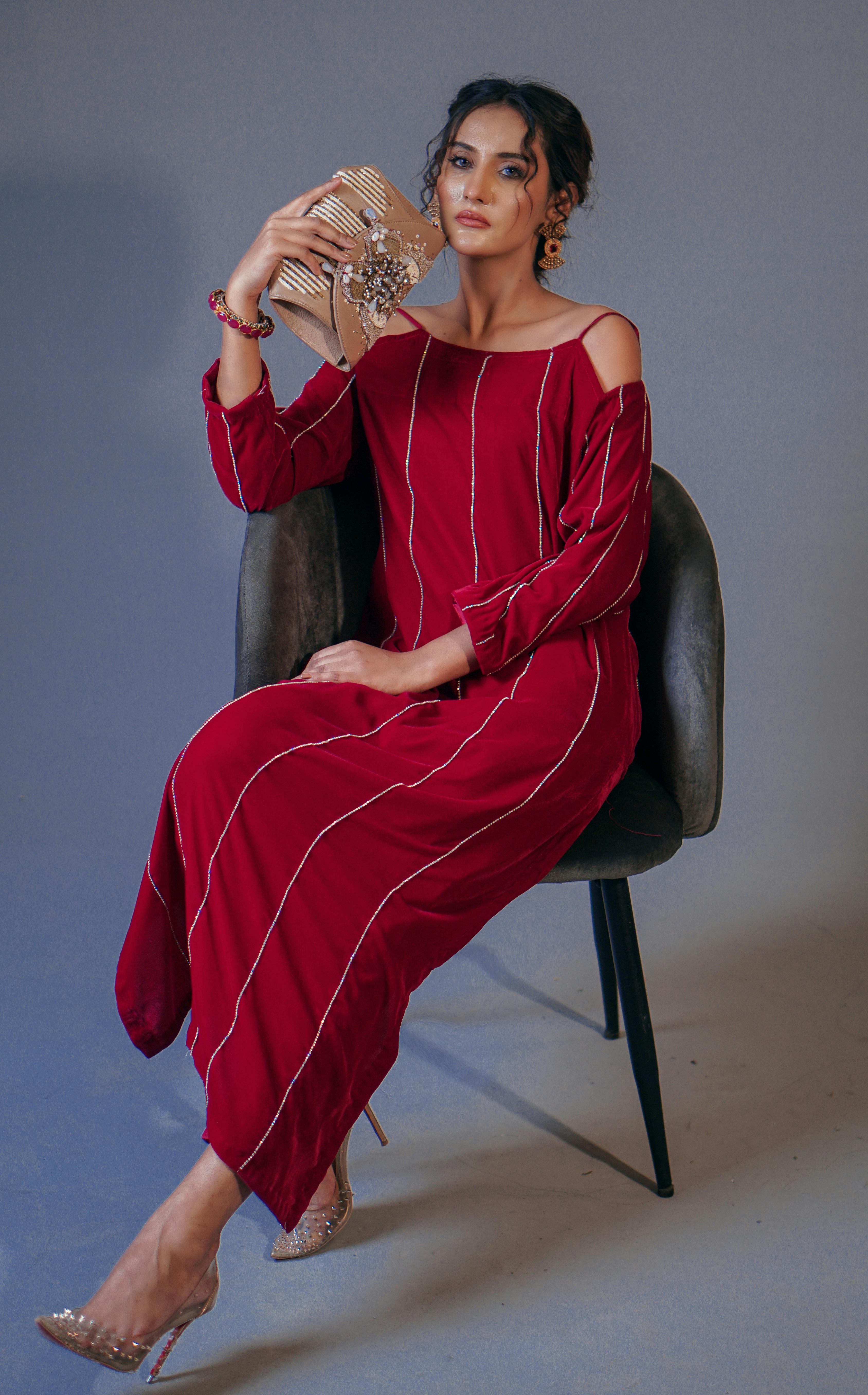 A Woman in Red Long Sleeve Dress Sitting on Black Chair · Free Stock Photo