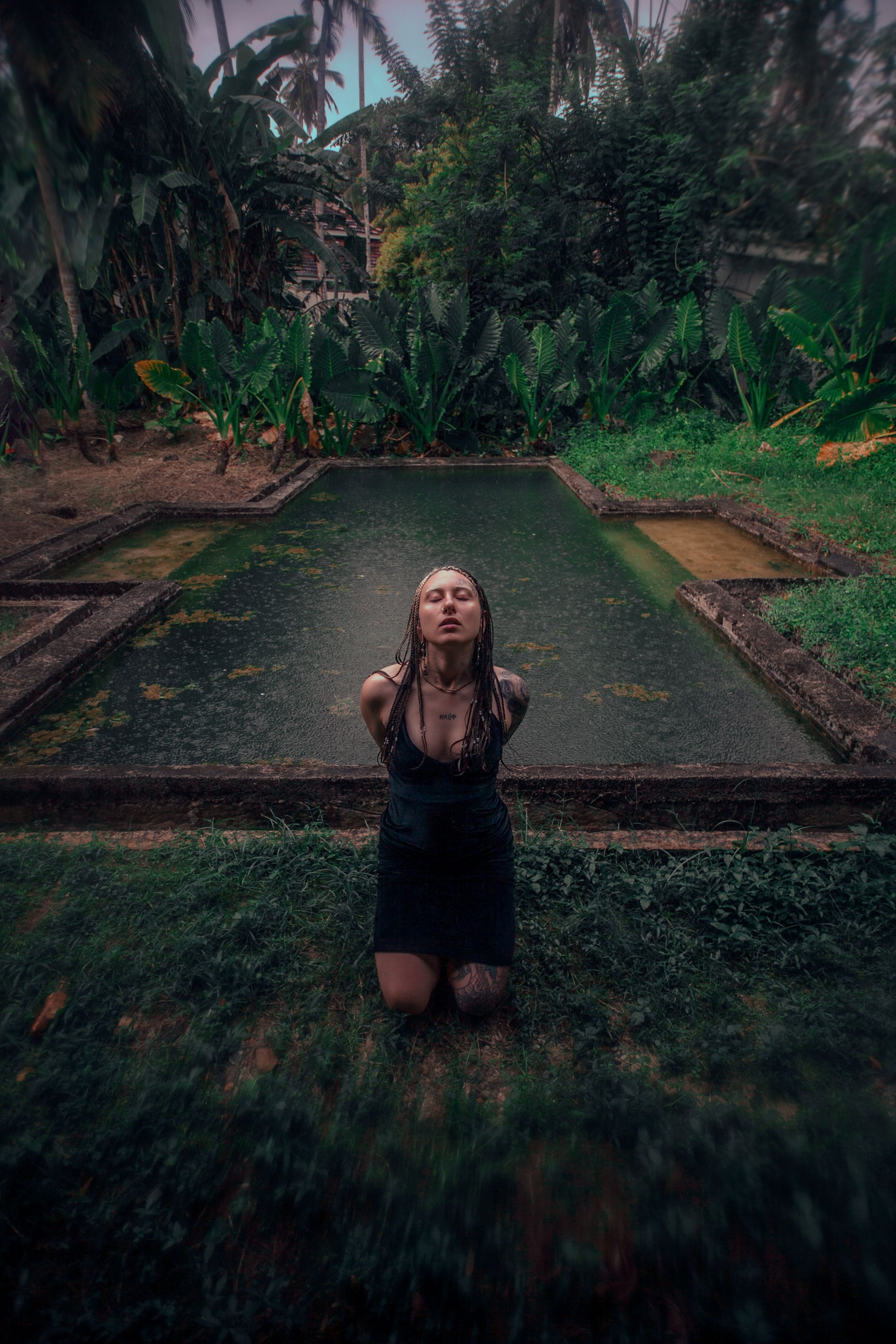 A Woman in Black Dress Kneeling Near the Pool · Free Stock Photo