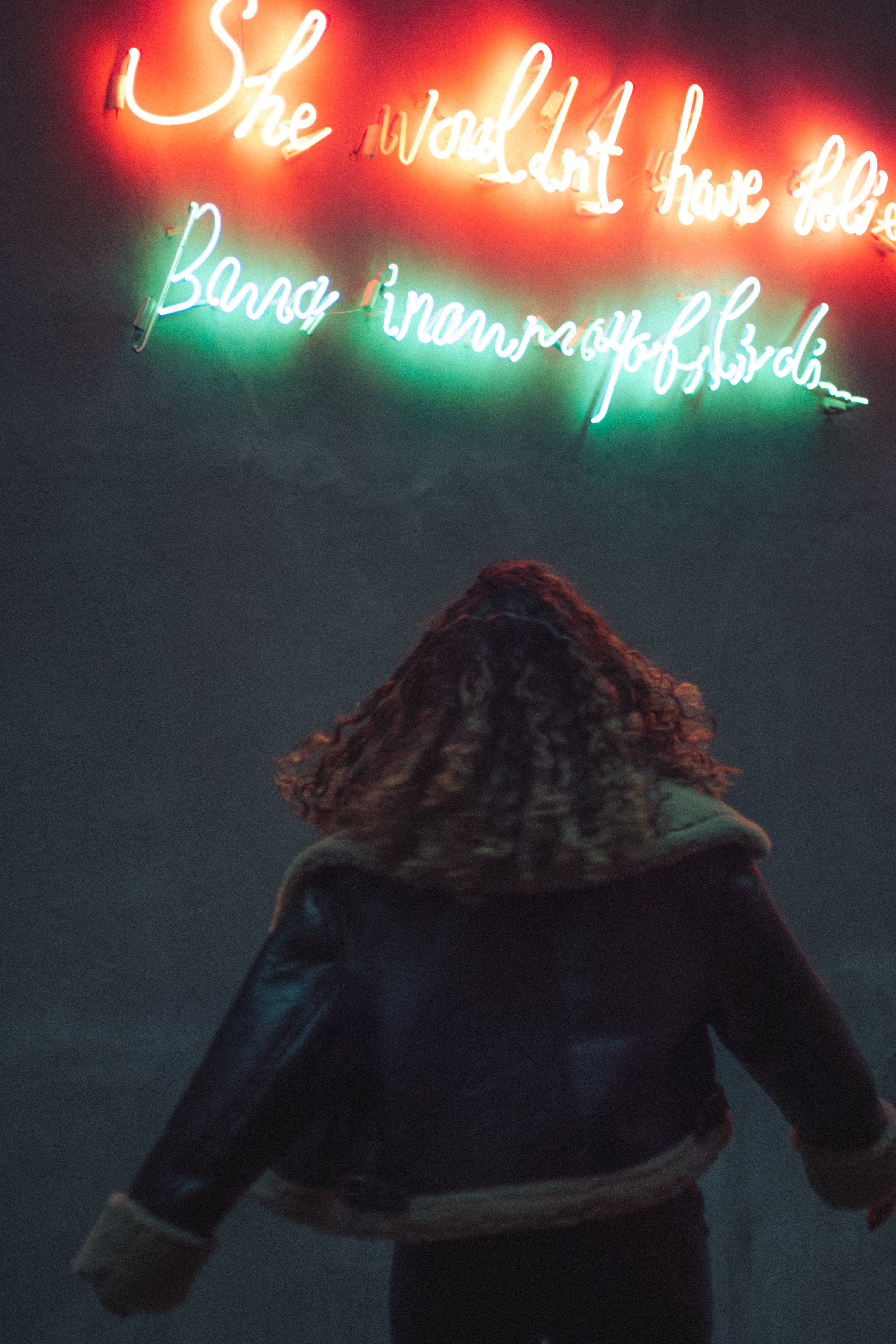 A Woman Standing by a Neon Sign · Free Stock Photo