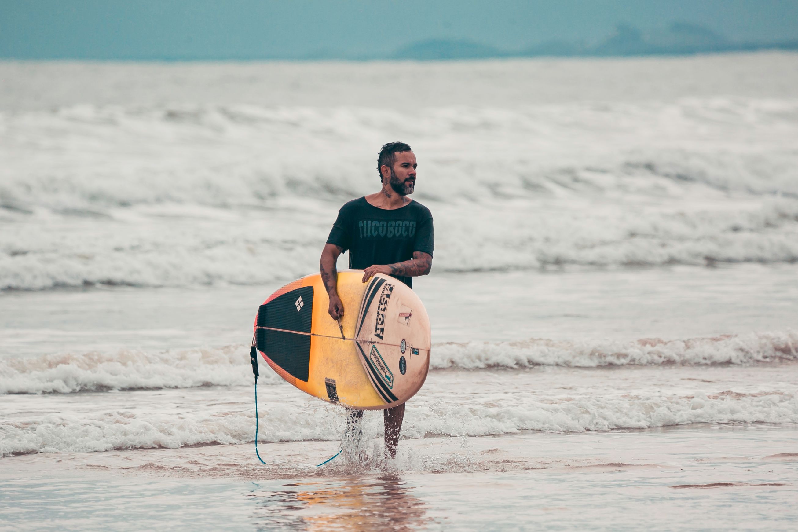 Photo of Man carrying a Surfboard · Free Stock Photo