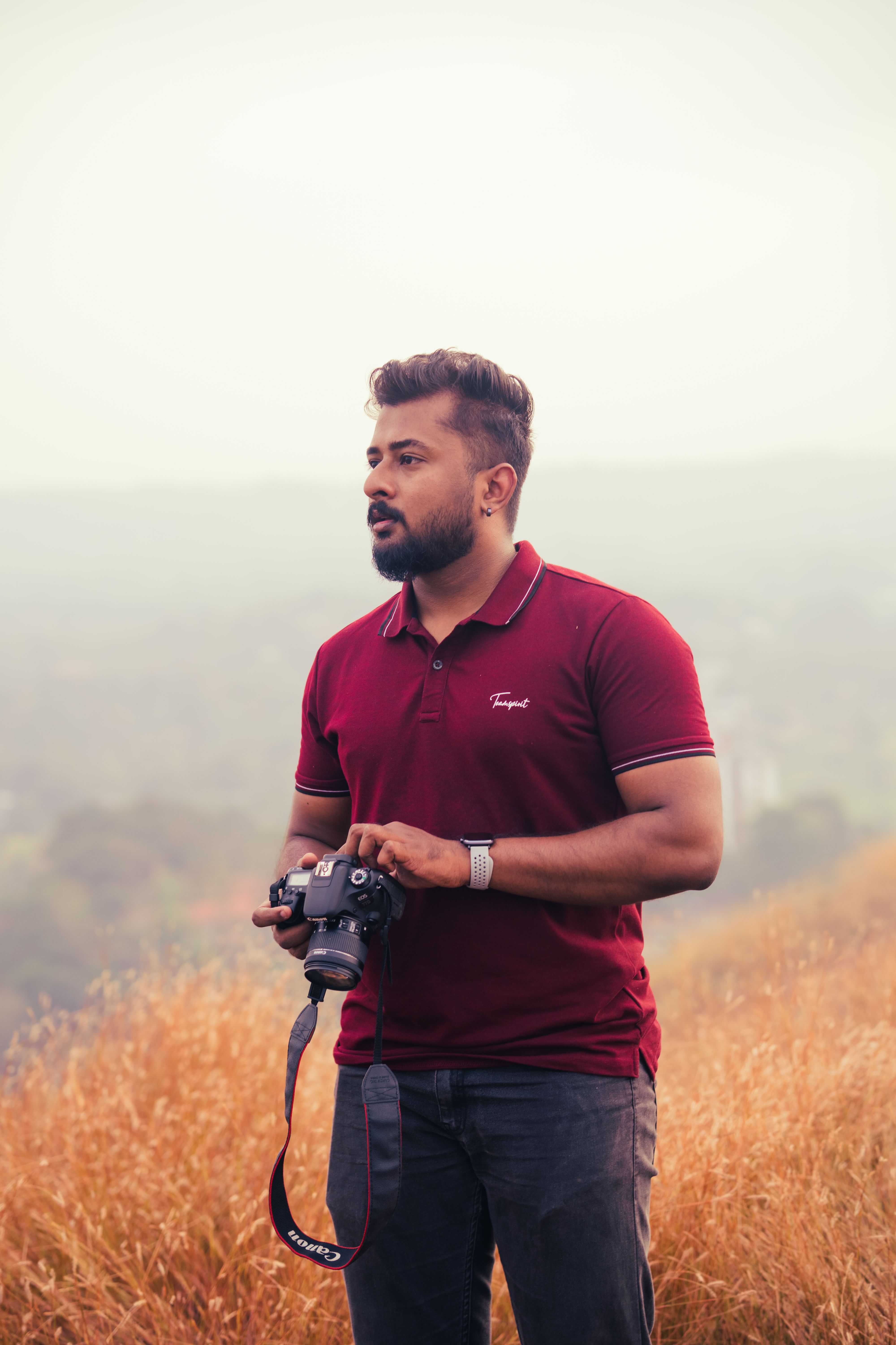 Man Holding Camera Standing in Field · Free Stock Photo