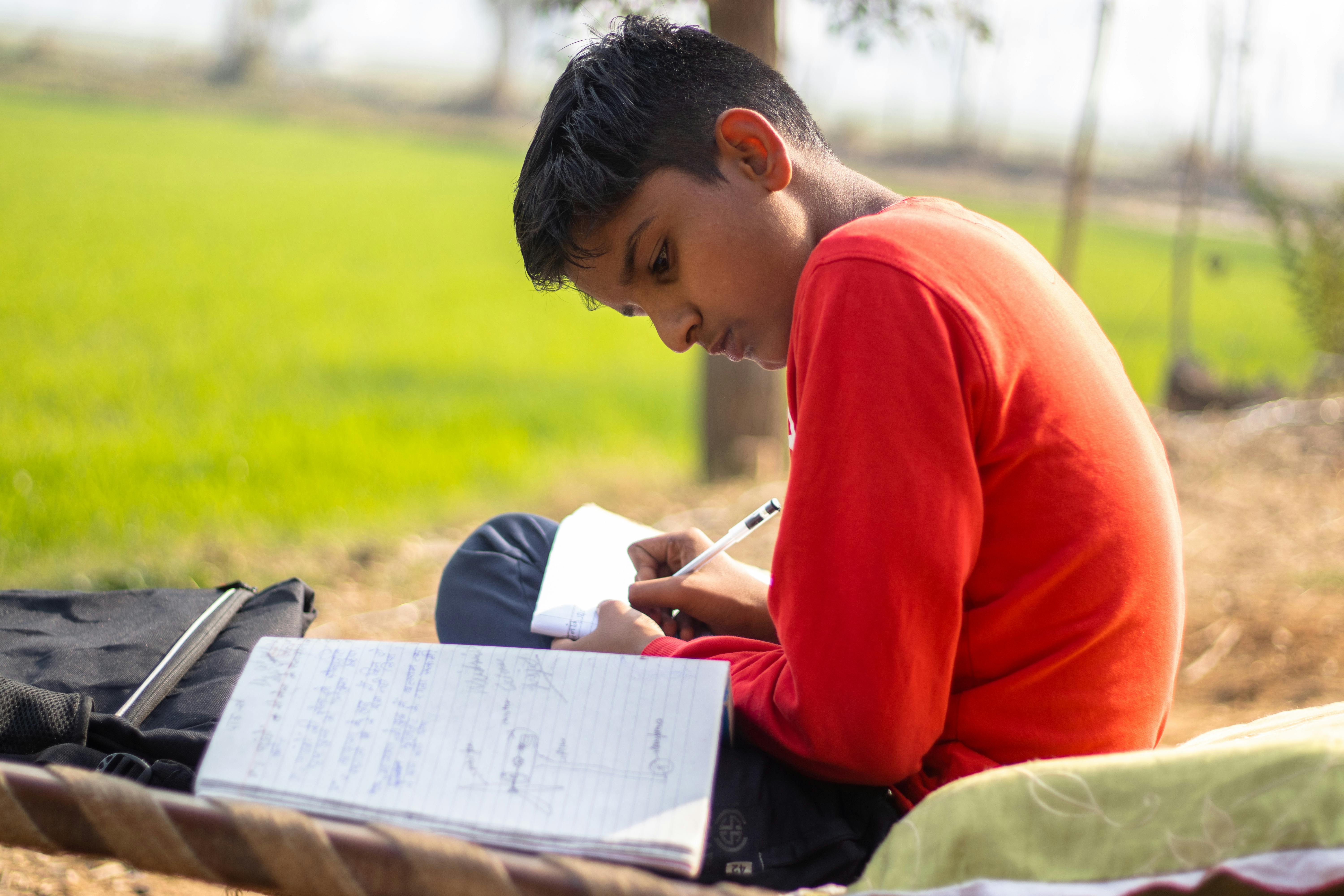 Student Writing on a Notebook · Free Stock Photo