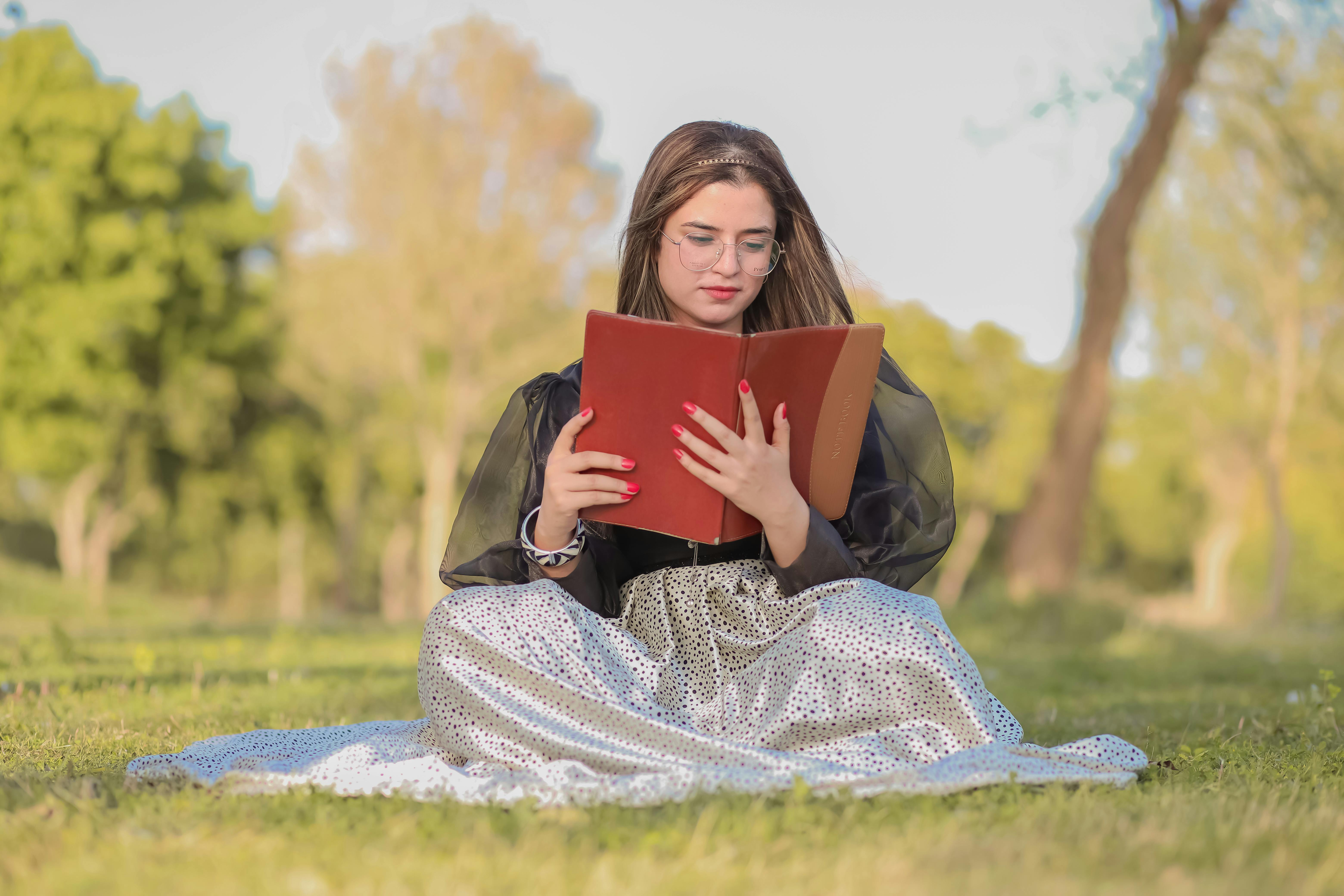 Photo of a Woman Sitting while Reading a Book · Free Stock Photo