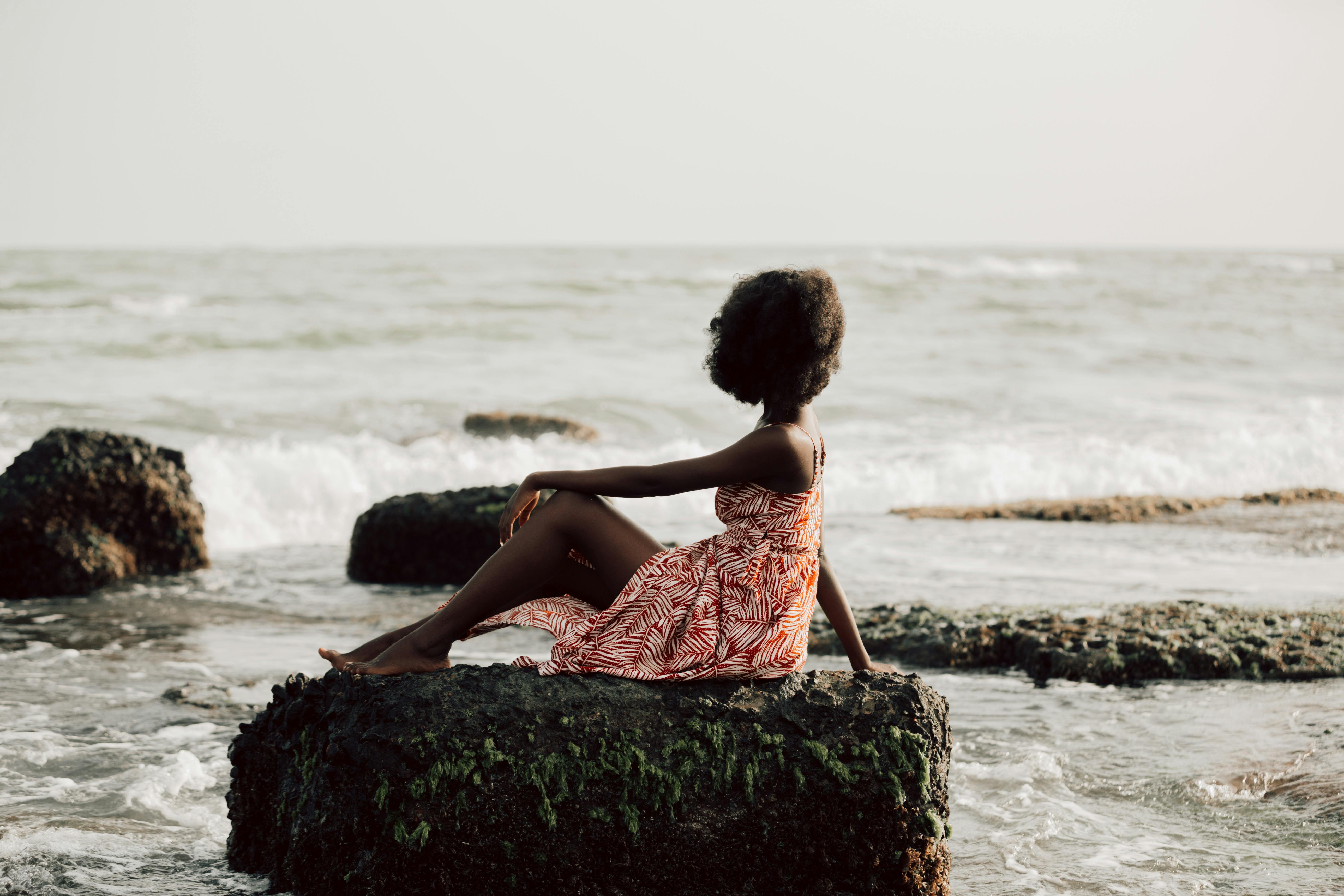 Woman Sitting on Stone at the Sea · Free Stock Photo