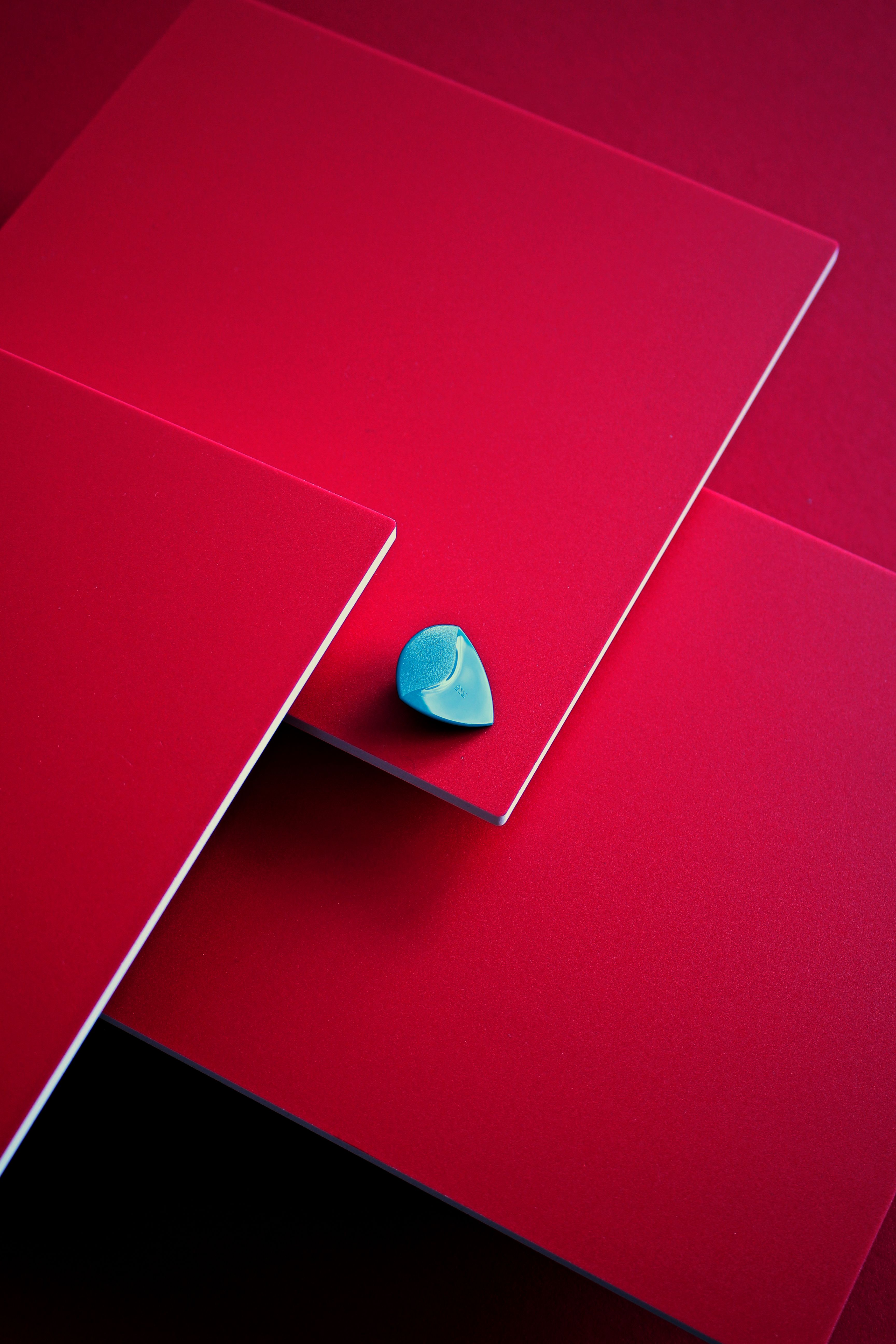 Close-up of a Guitar Pick Lying on Pink Background · Free Stock Photo
