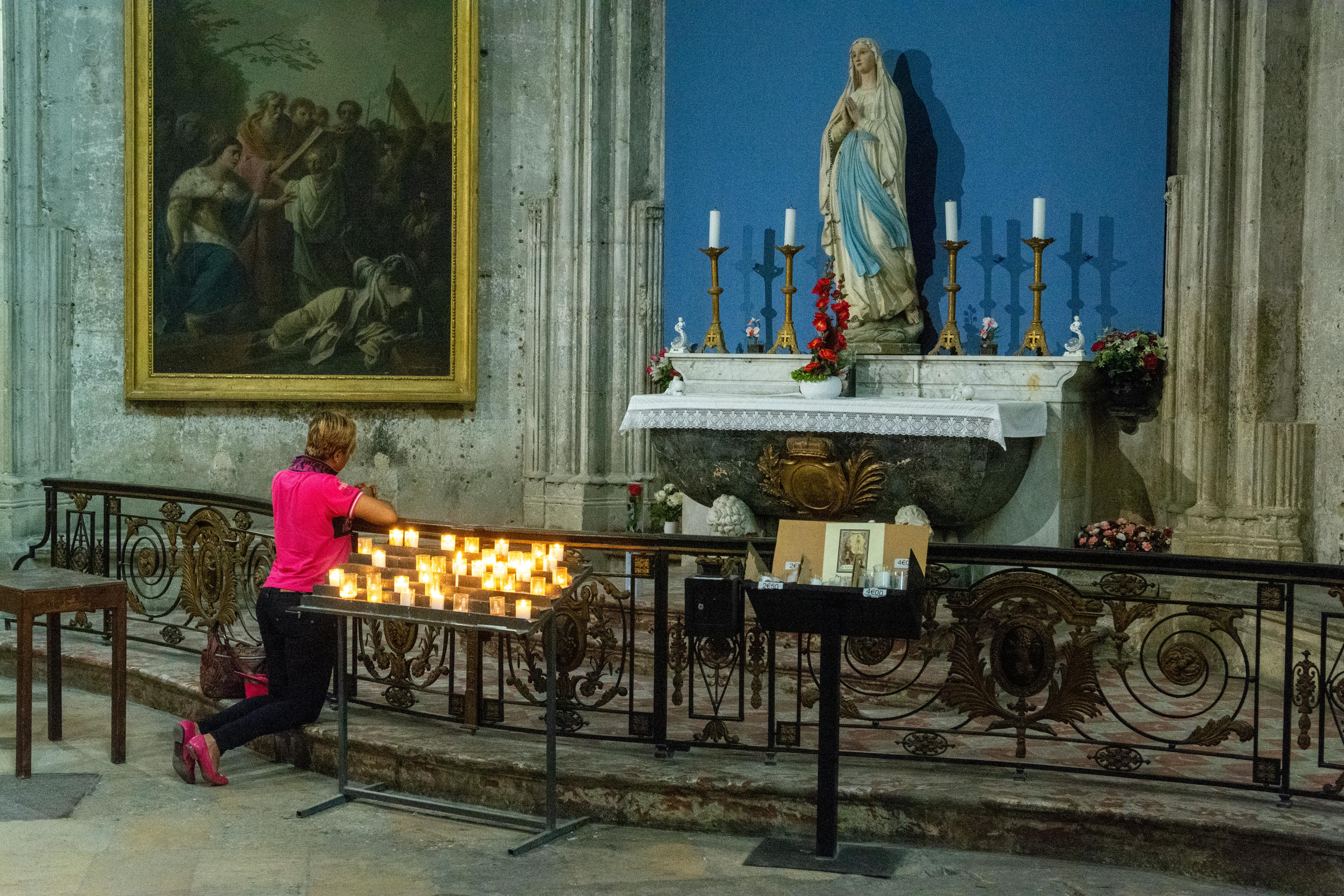 A Woman Praying on the Altar Near Lighted Candles · Free Stock Photo