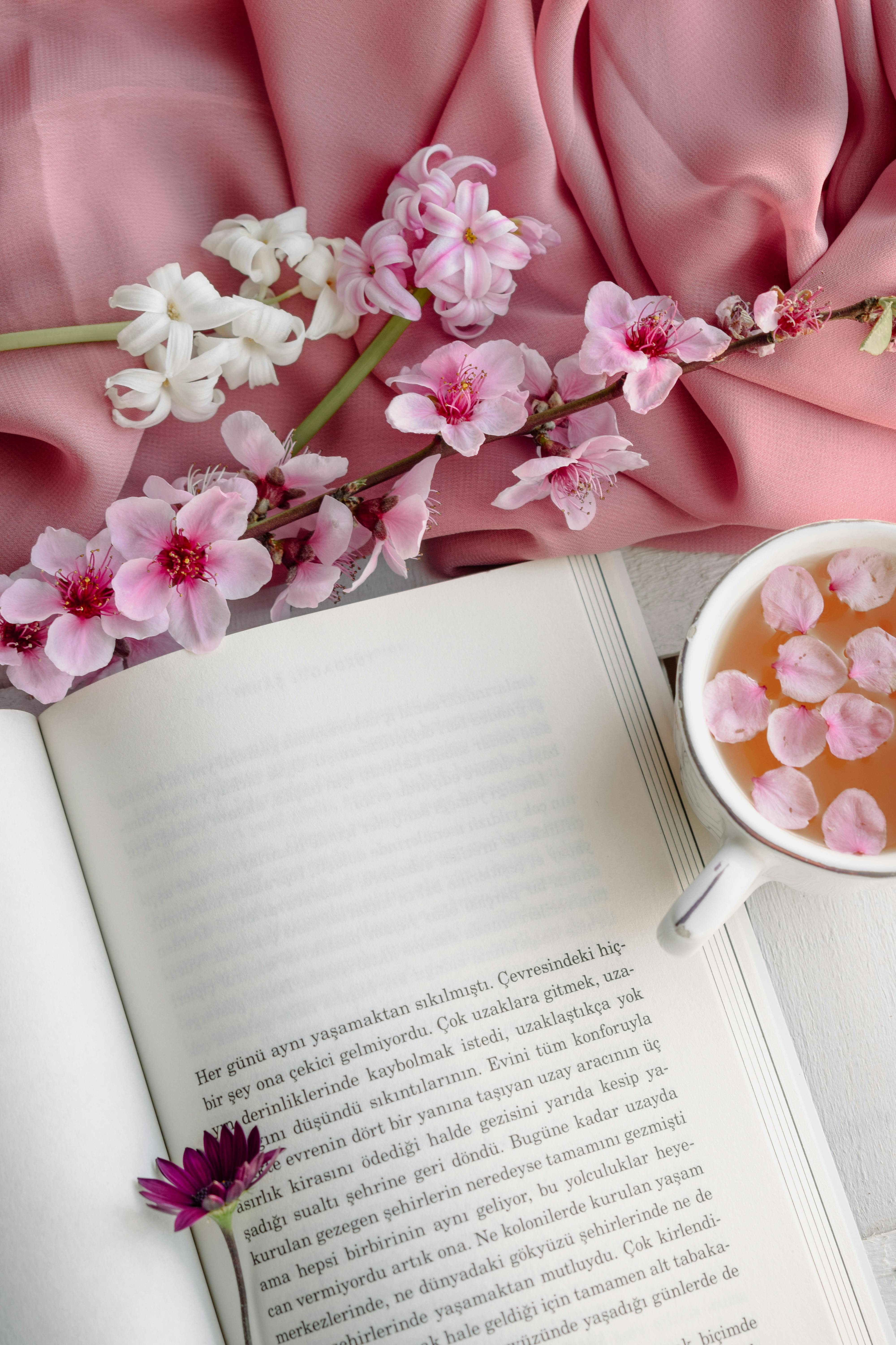 A book and cup of tea with pink flowers · Free Stock Photo
