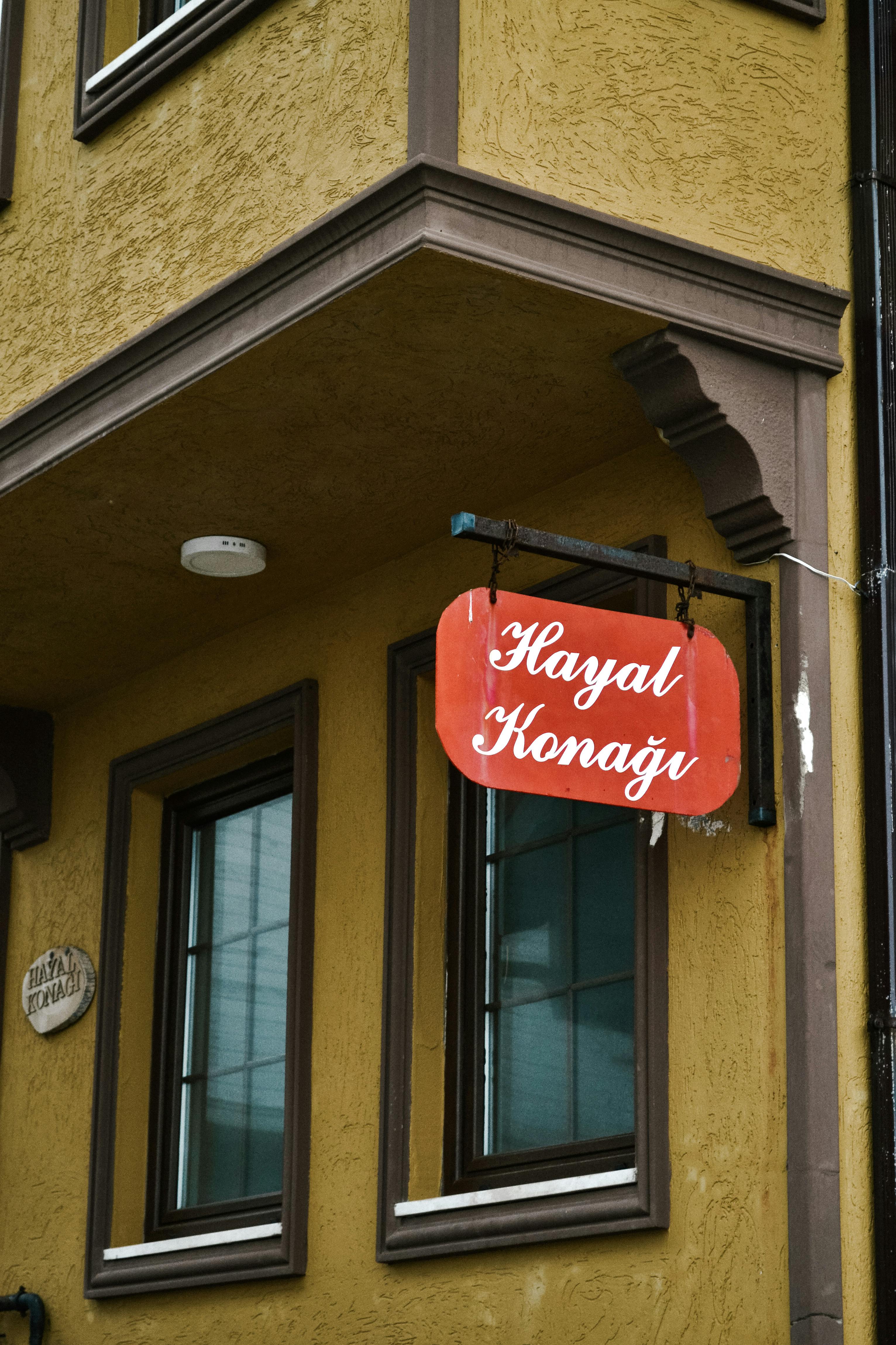 Sign Hanging on Building Wall · Free Stock Photo