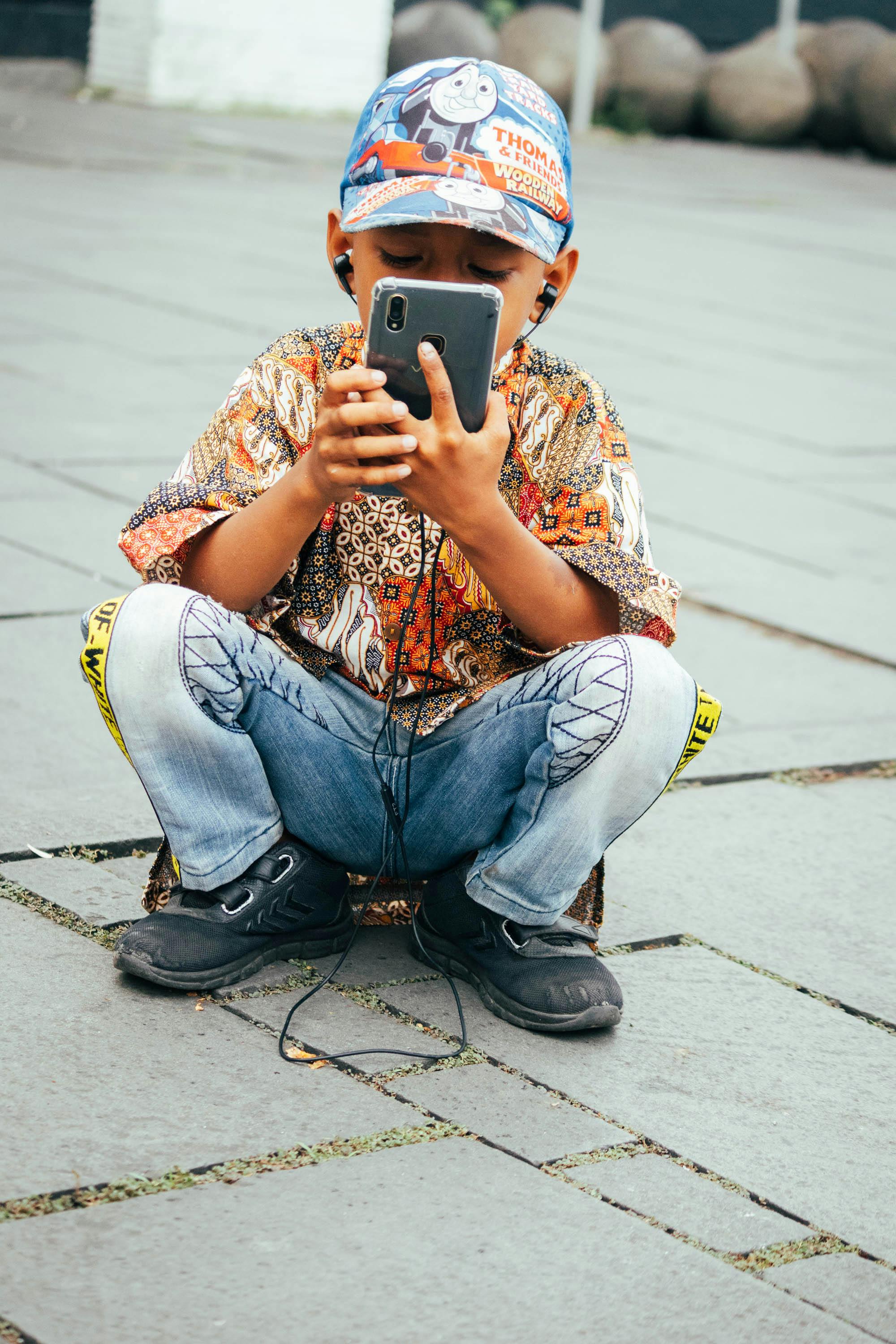 A Boy Holding a Smartphone · Free Stock Photo