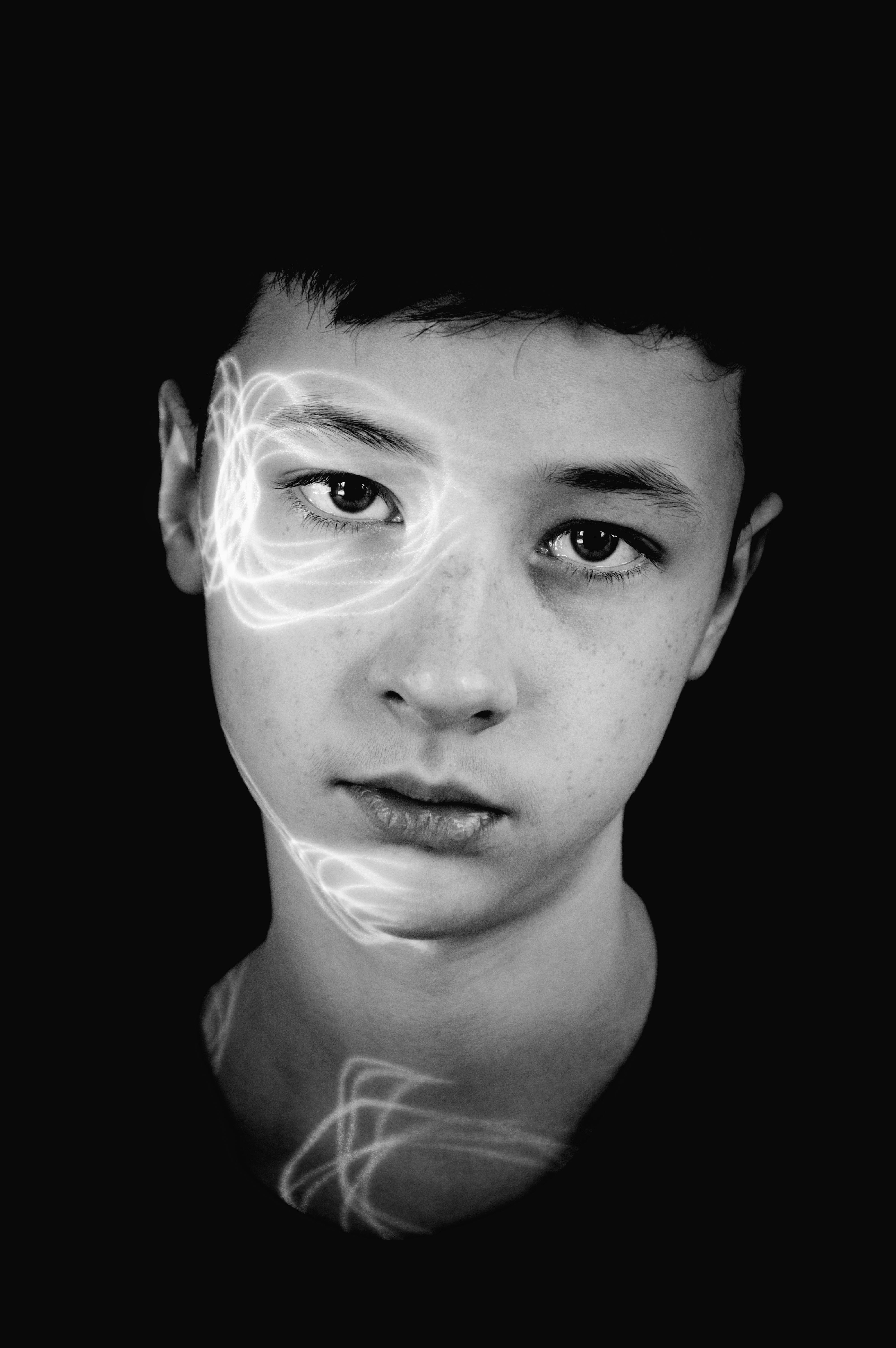 Portrait of a Young Boy with Flower Shadows on His Face · Free Stock Photo