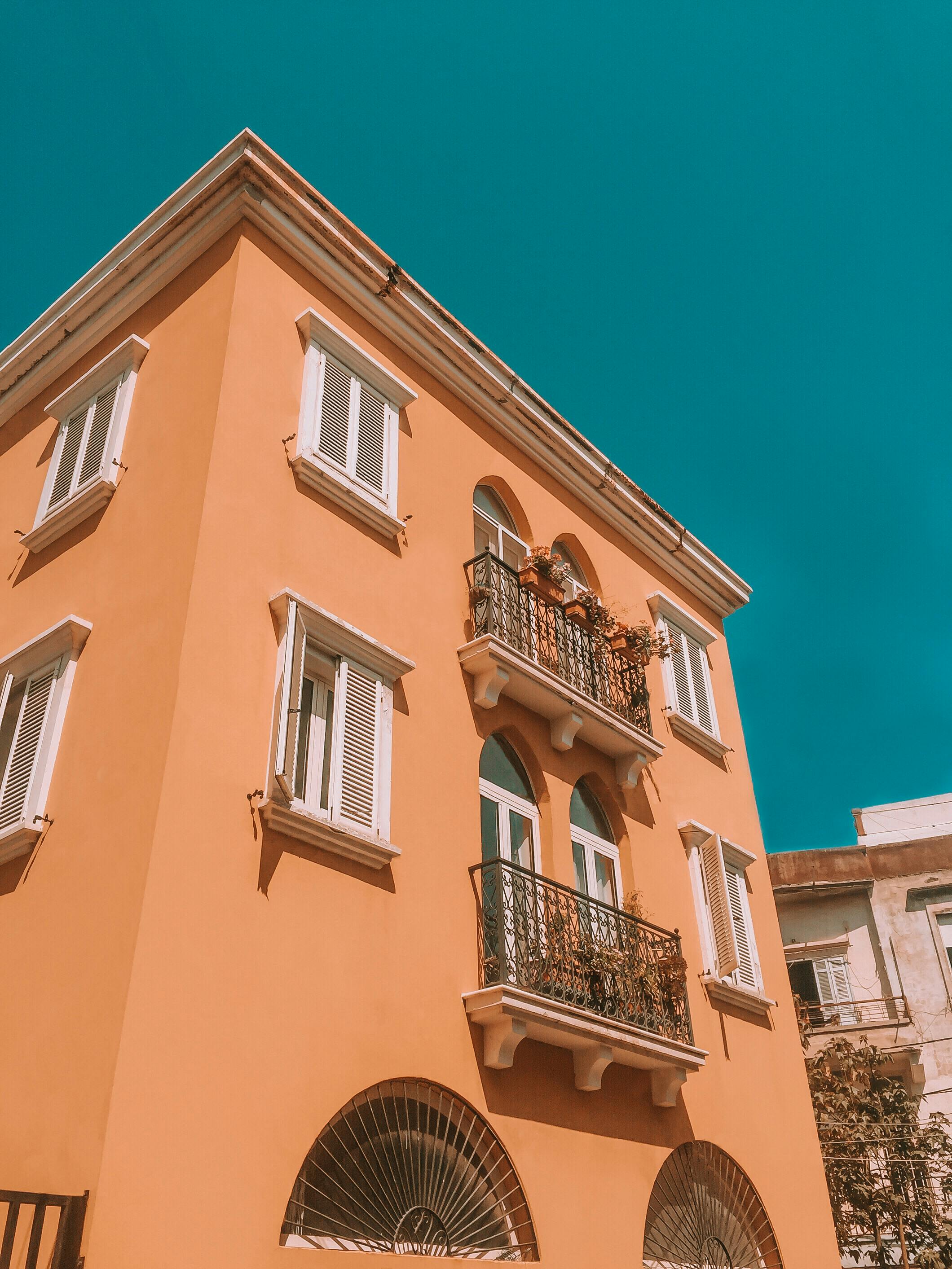 Clear Sky over Sunlit Building Wall · Free Stock Photo