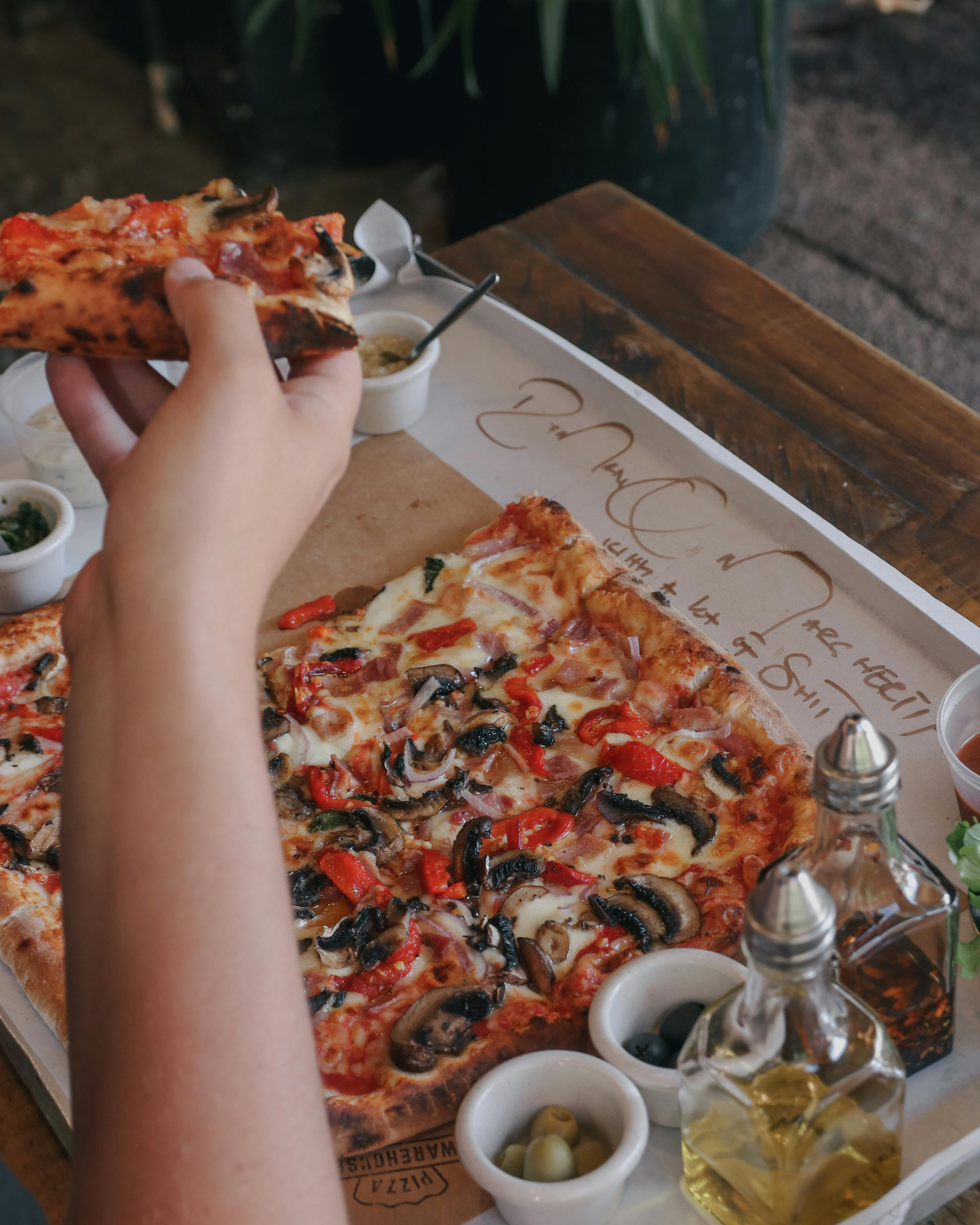 Hand Holding Pizza · Free Stock Photo