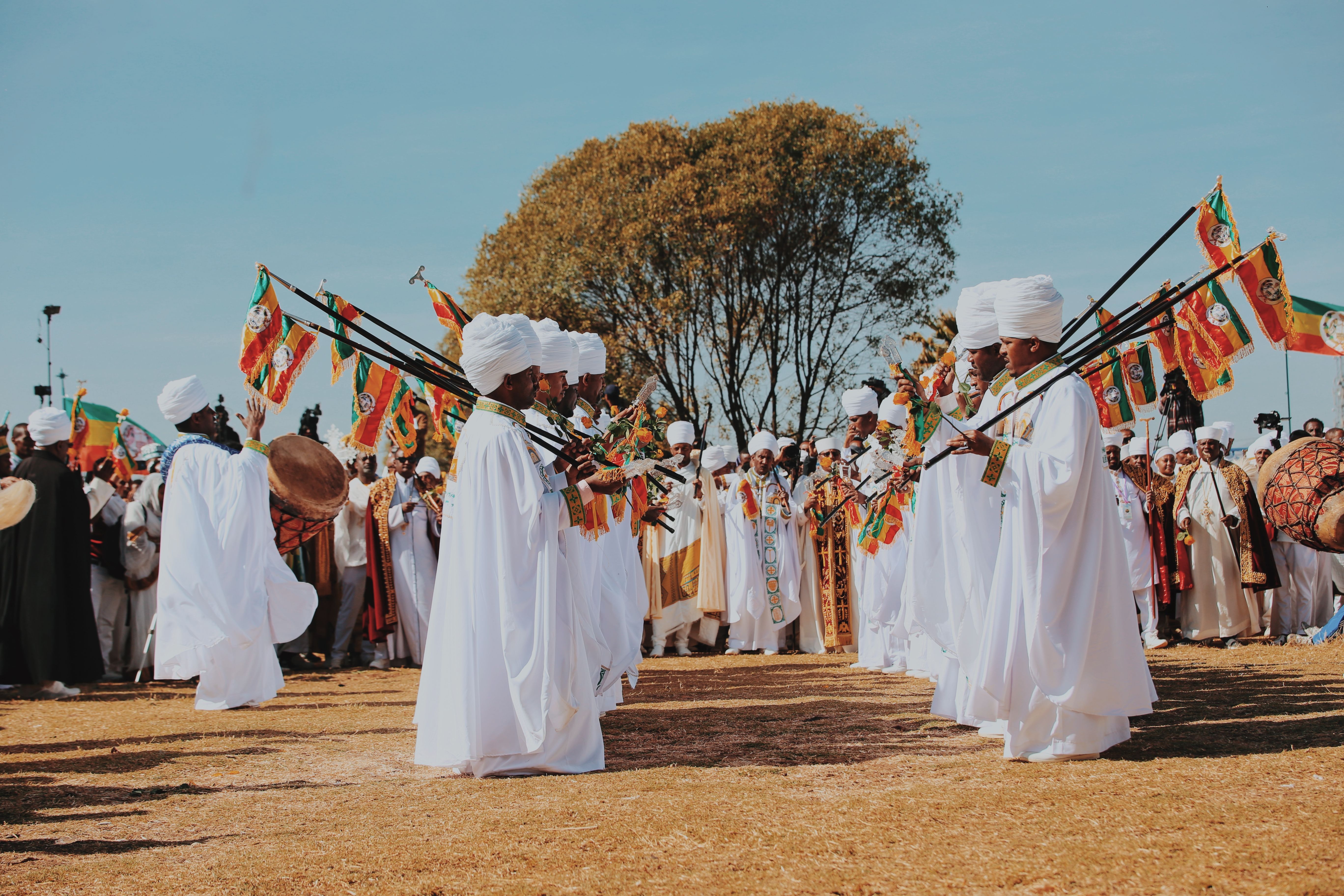 Men in Traditional Clothing Standing in Rows and Holding Flags · Free ...