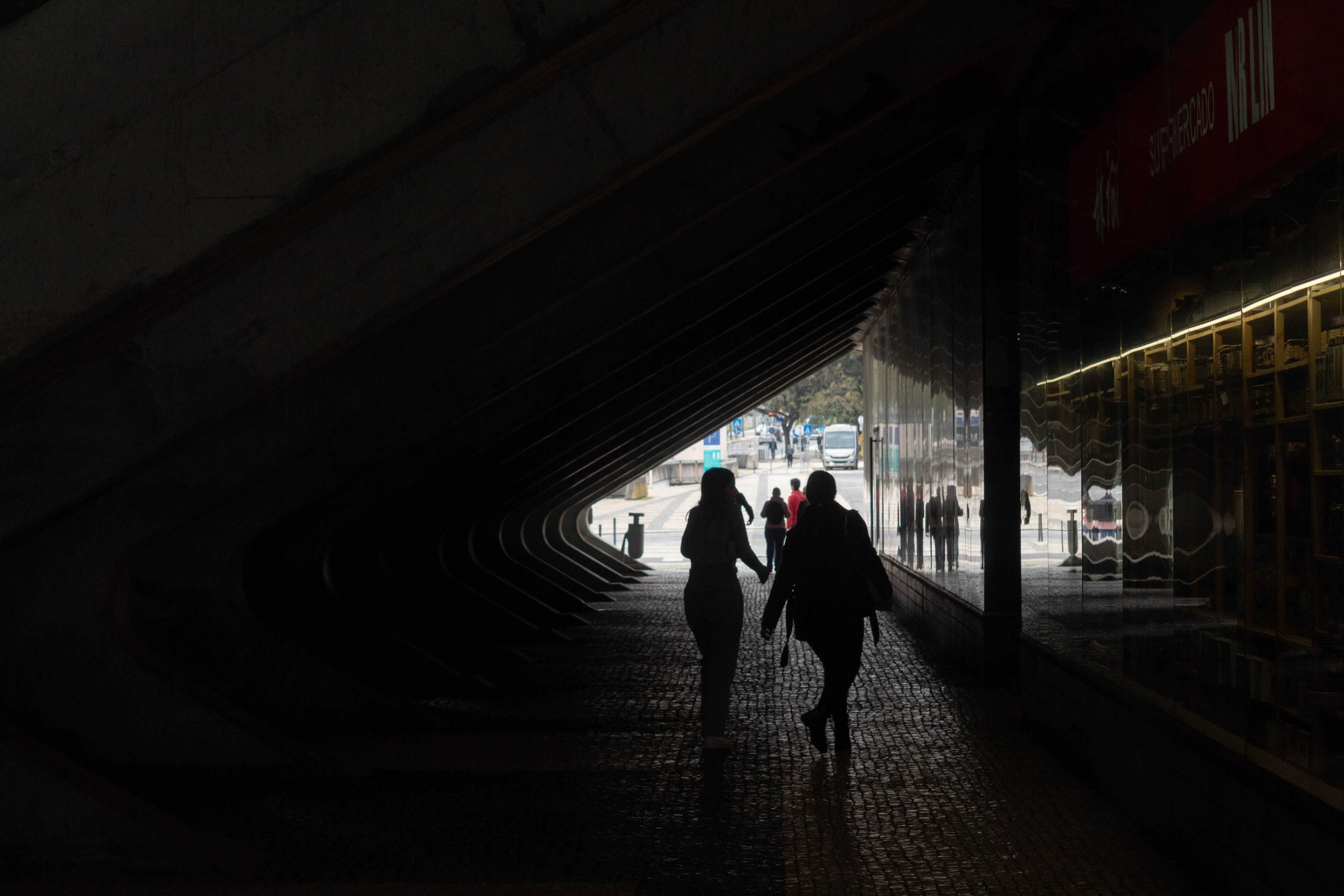 Back View of People Walking through a Tunnel · Free Stock Photo