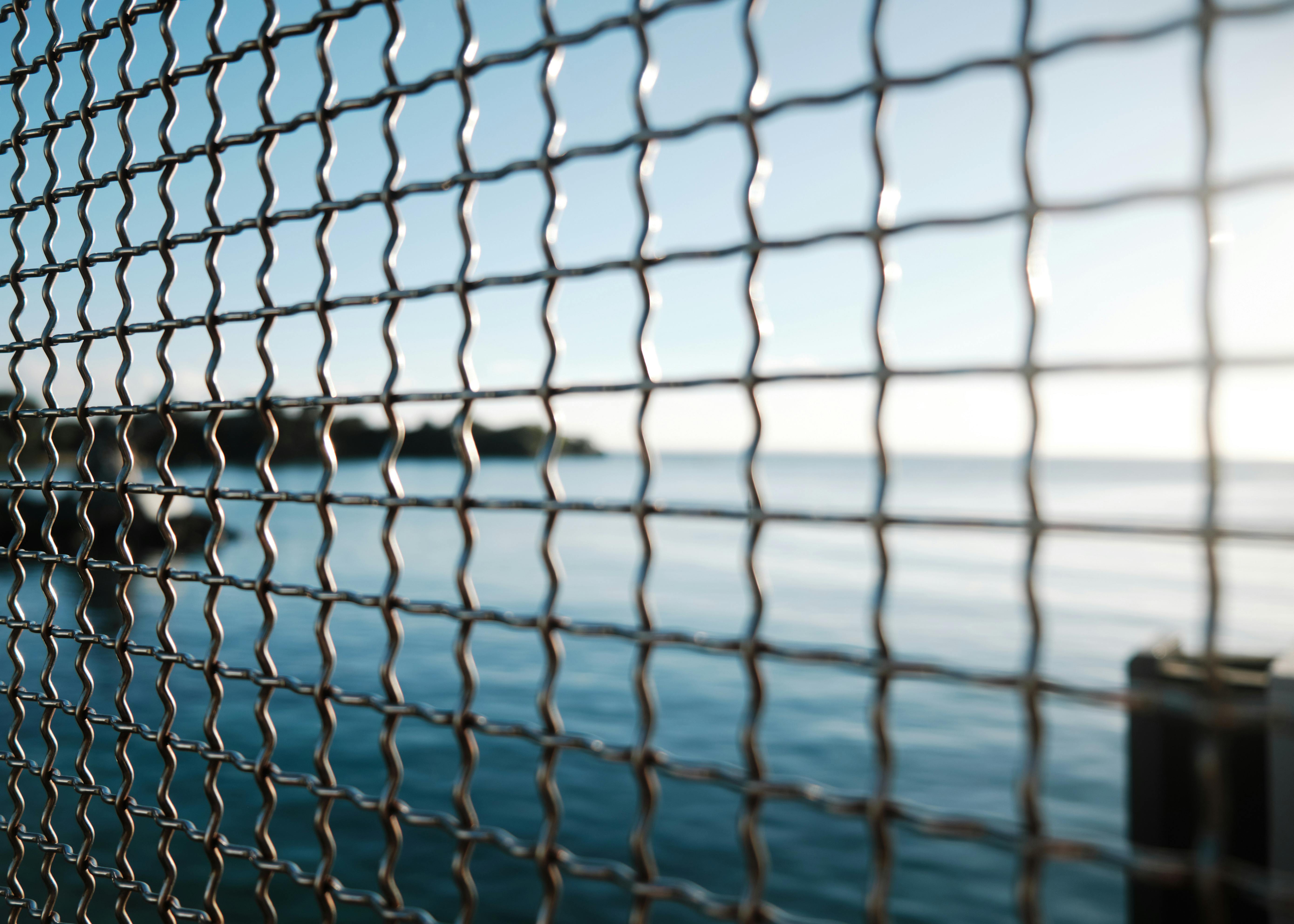 Netting Fence and Sea · Free Stock Photo