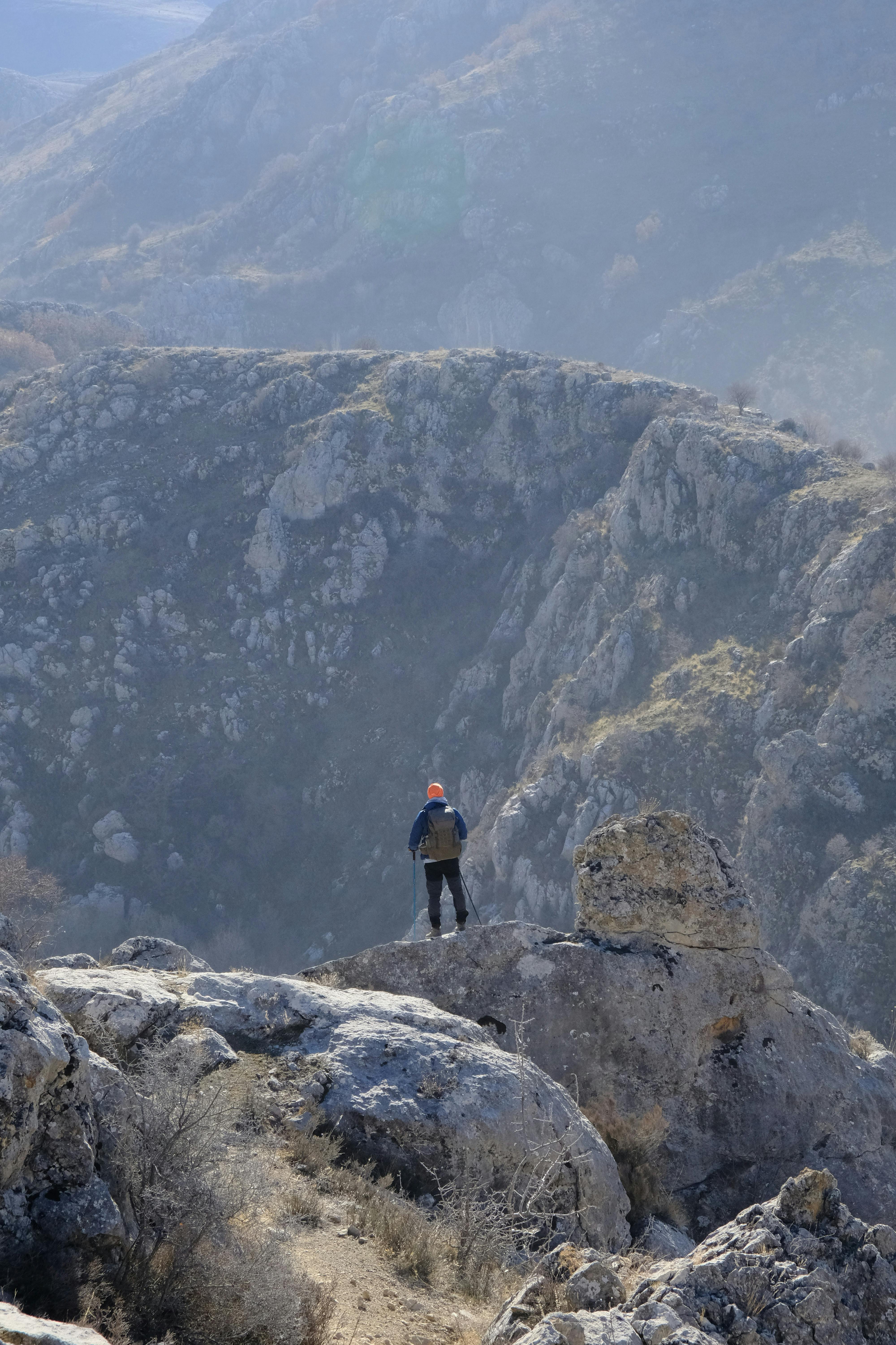 A Person Standing on Rocky Mountain · Free Stock Photo