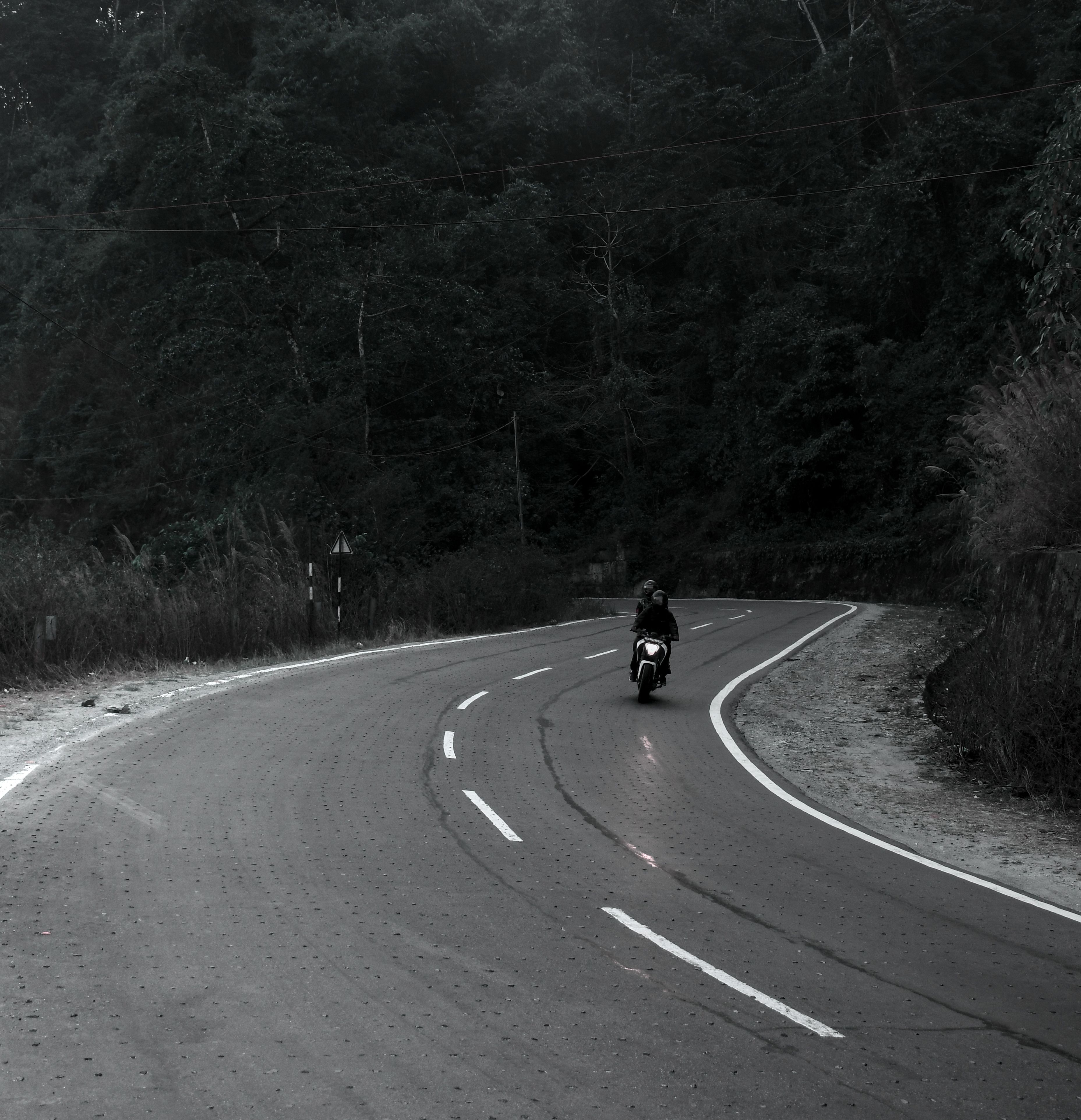 Motor Scooter is Driving on Winding Road · Free Stock Photo