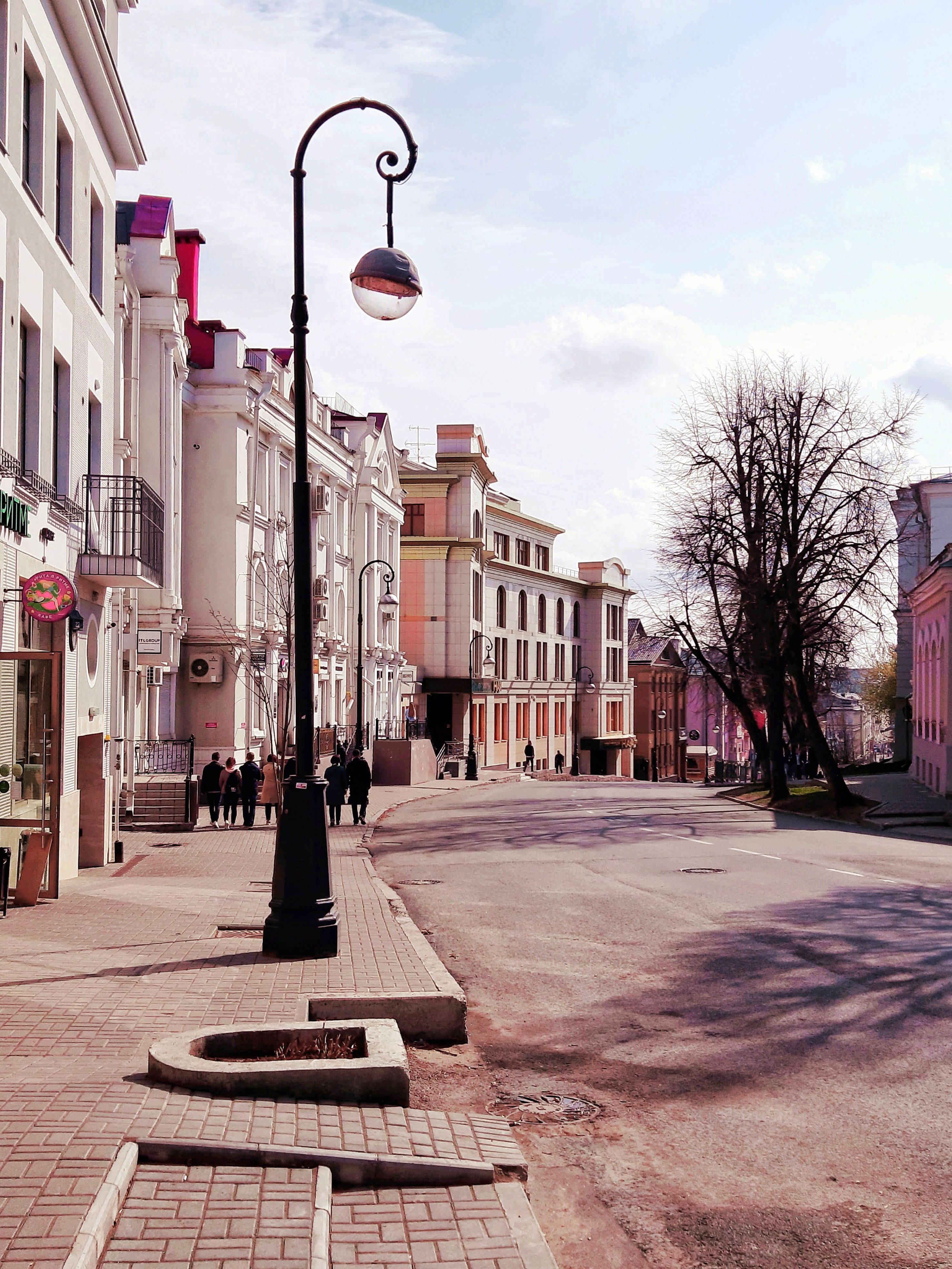 A street with a lamp post and a street sign · Free Stock Photo