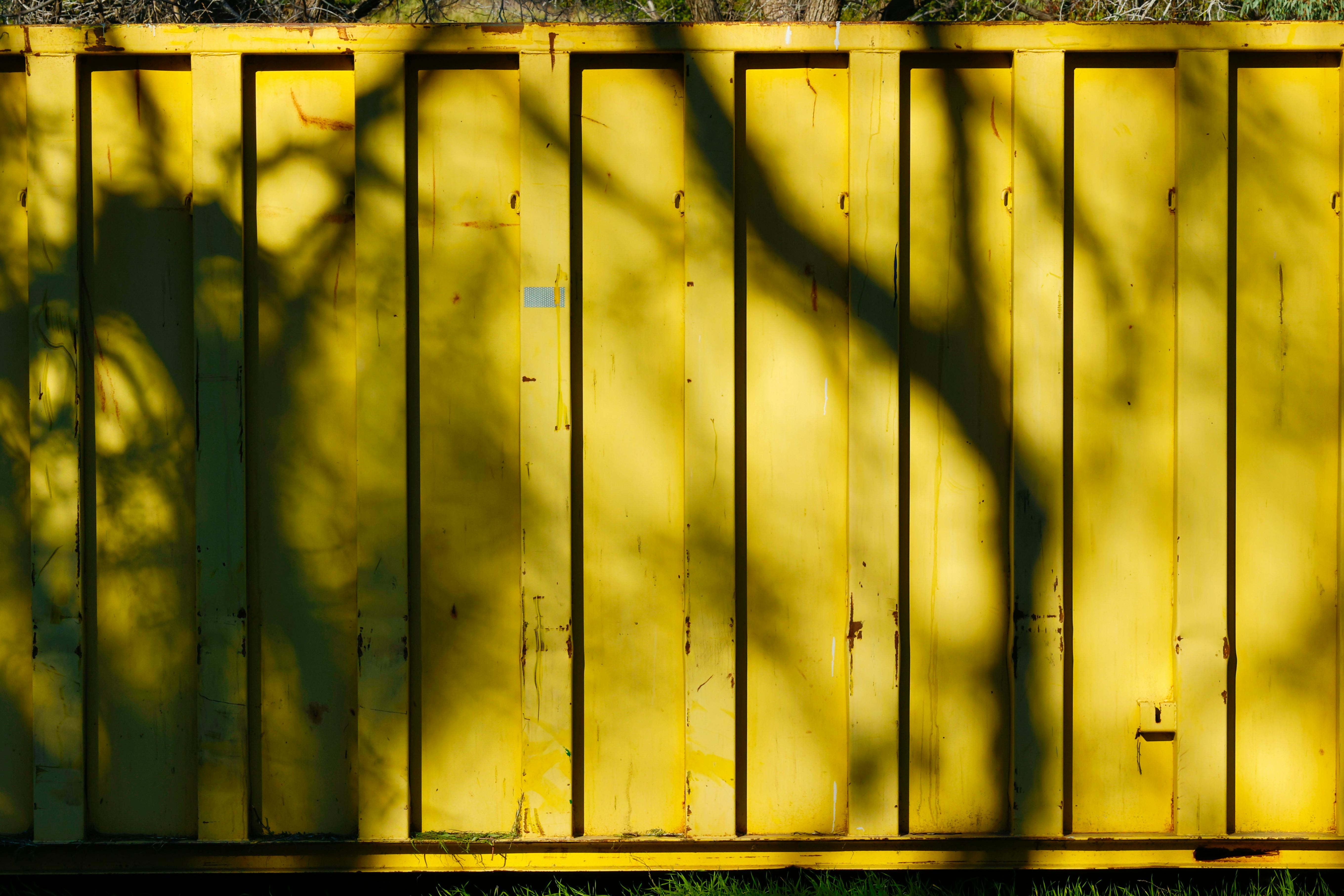 Shadows of Trees on a Yellow Container · Free Stock Photo