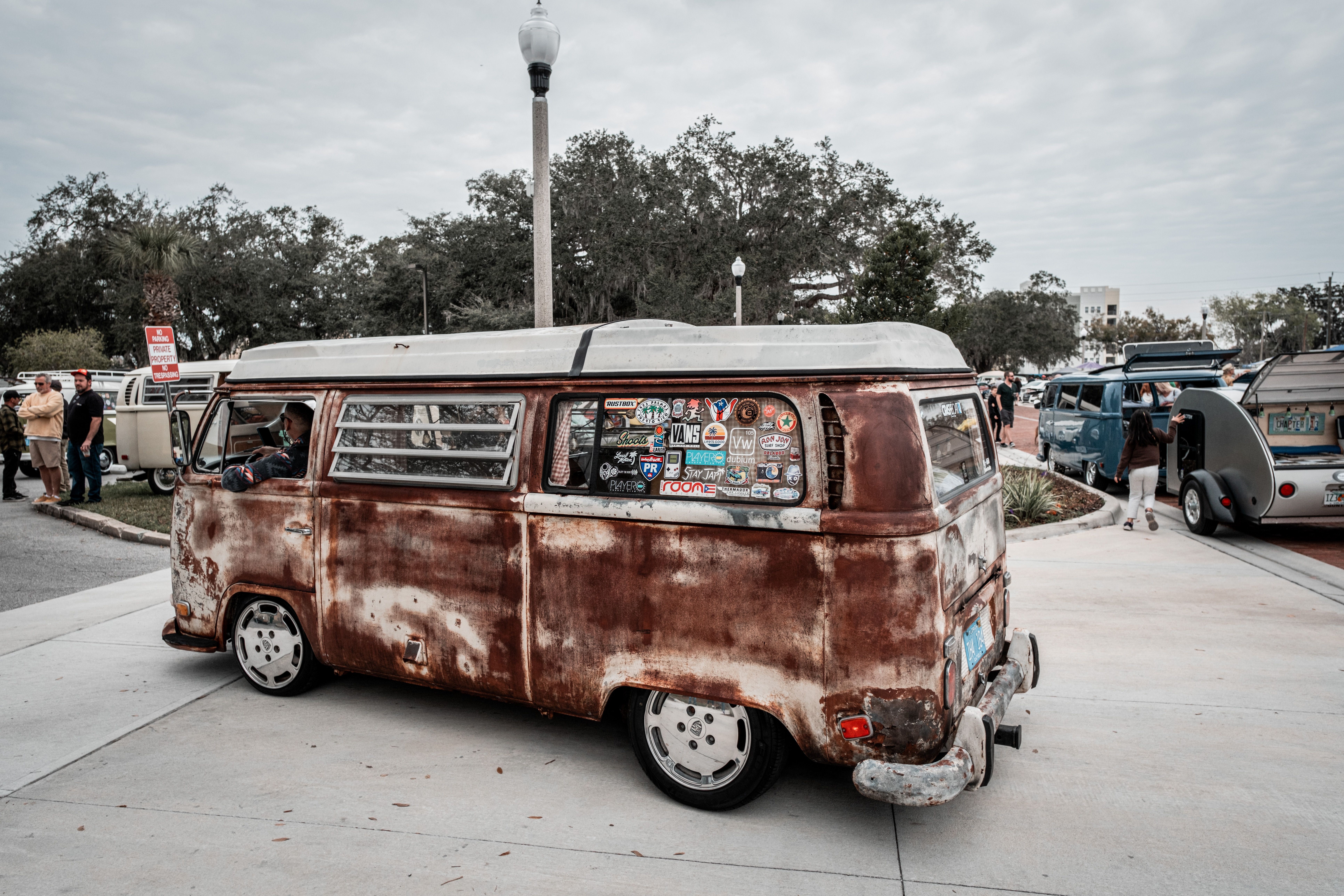 A rusty old vw bus parked on the side of the road · Free Stock Photo