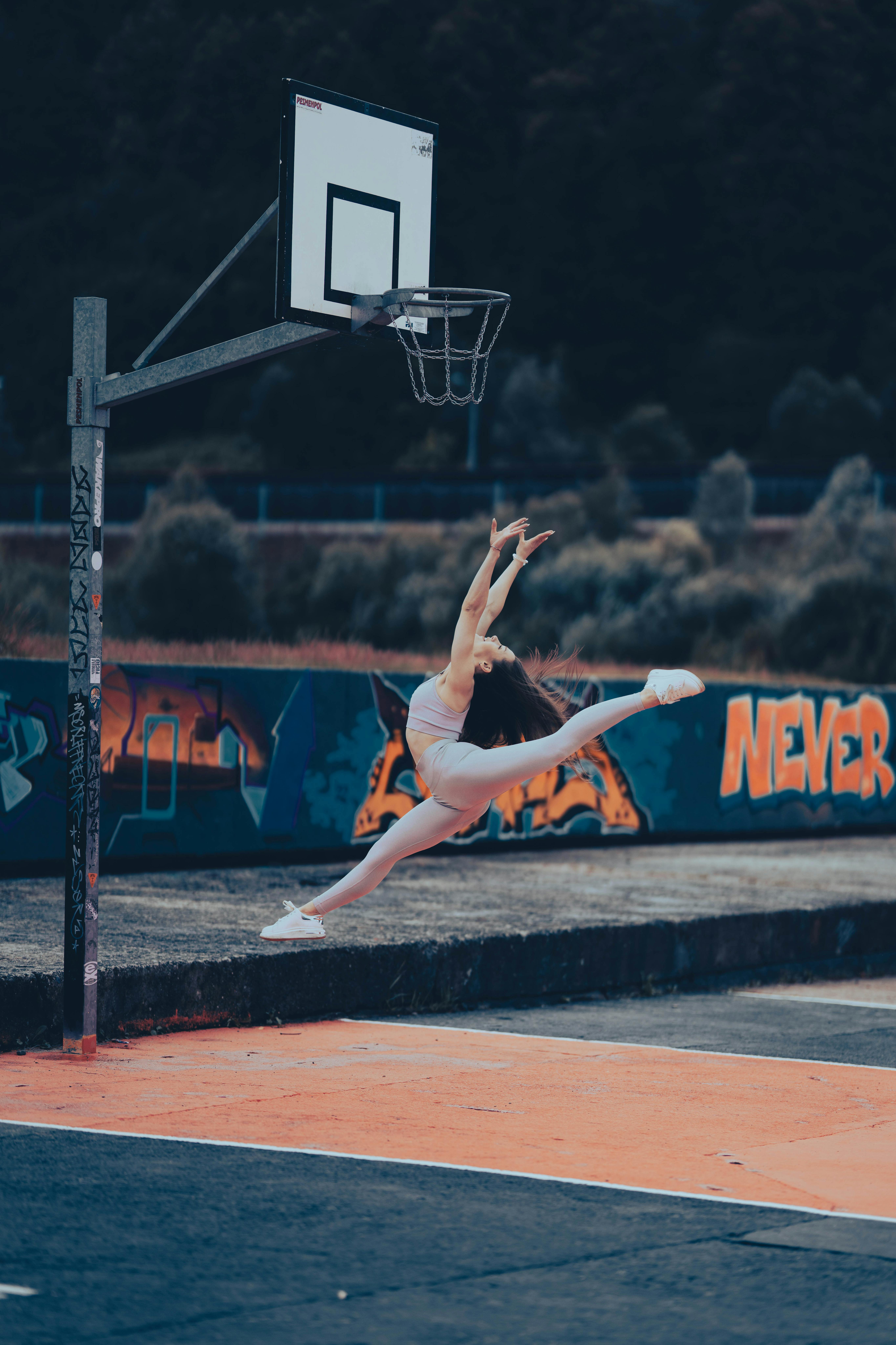 Woman Jumping on Basketball Pitch · Free Stock Photo