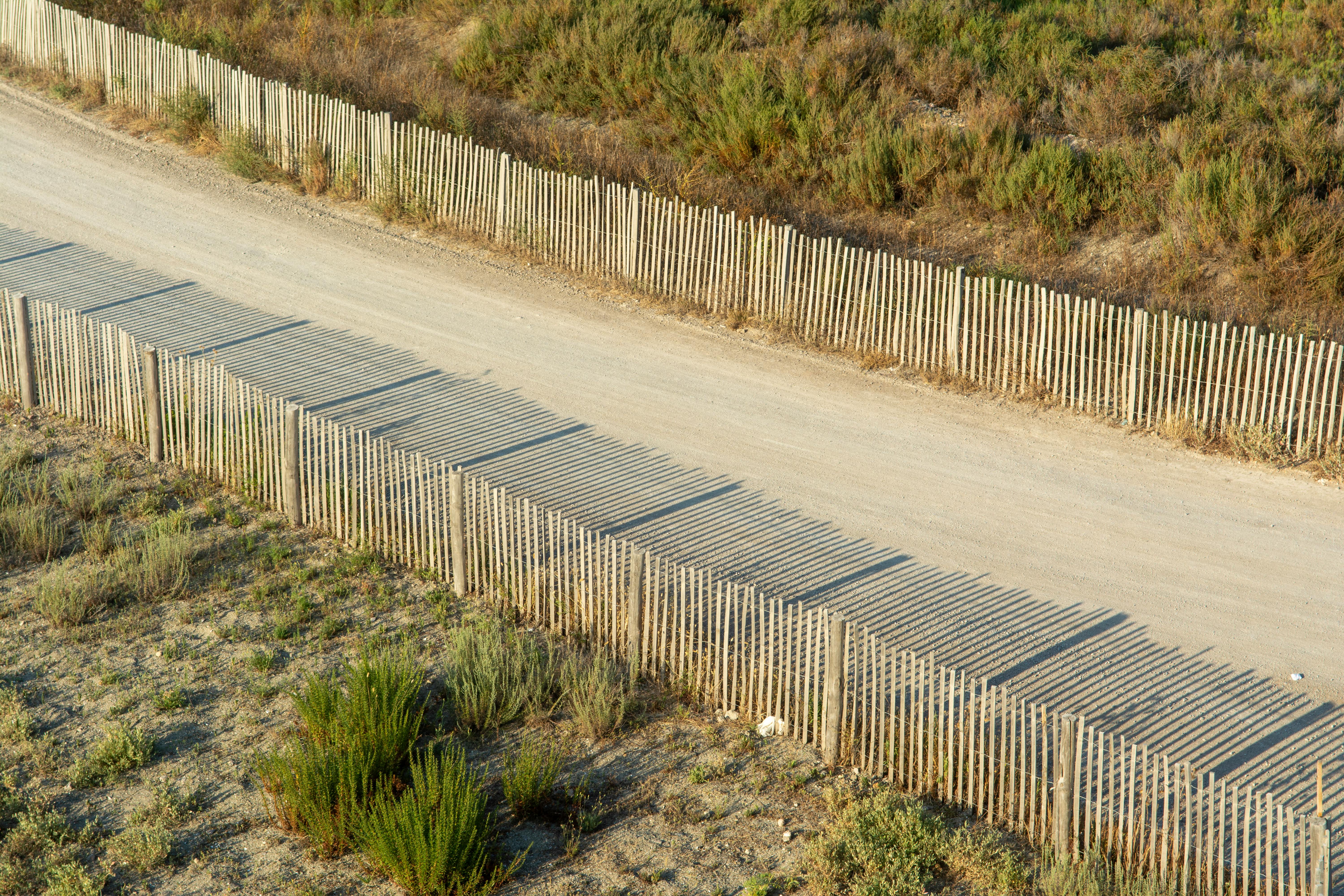An aerial view of a road with a fence · Free Stock Photo