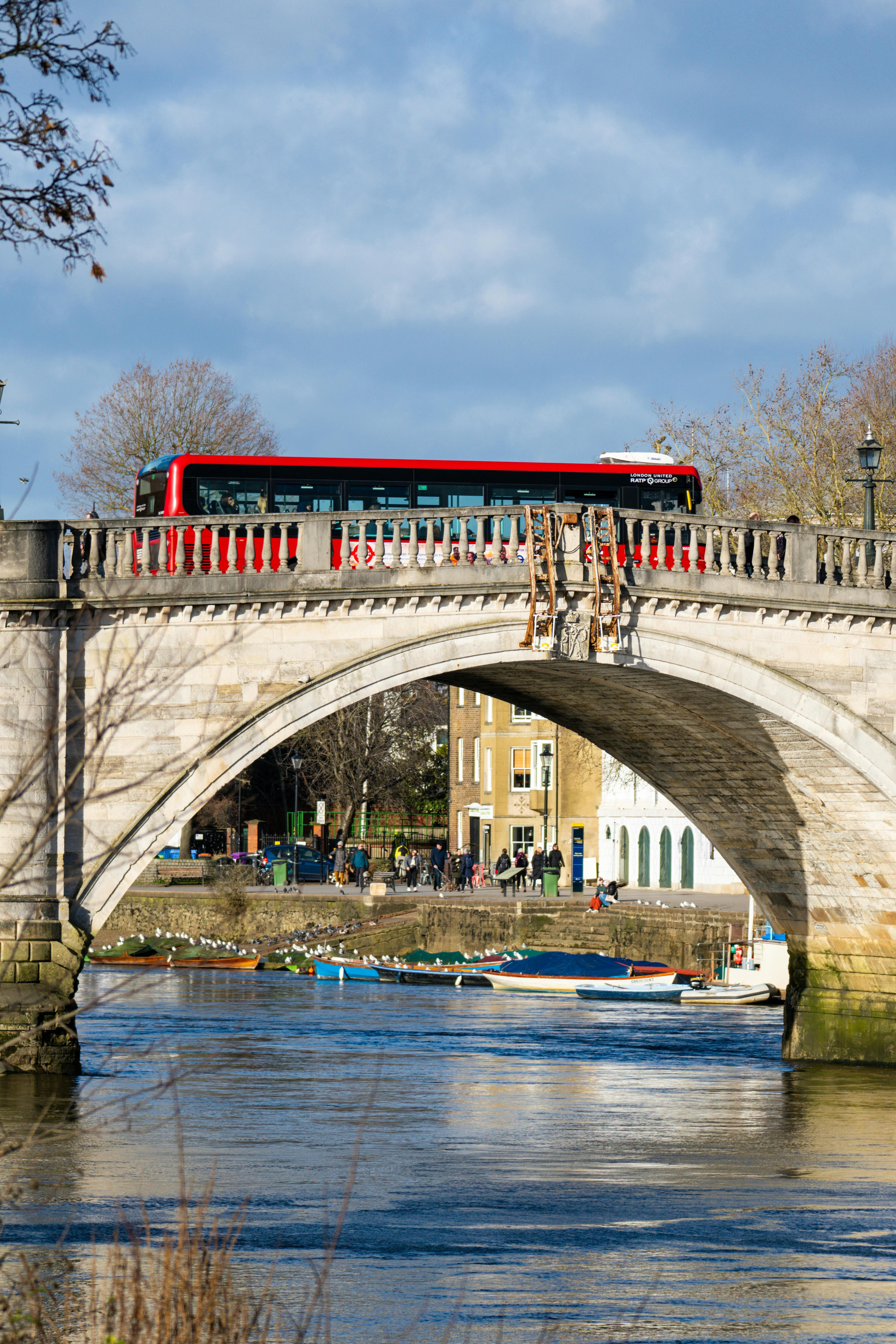 Red Bus Running on a Bridge Over a River · Free Stock Photo