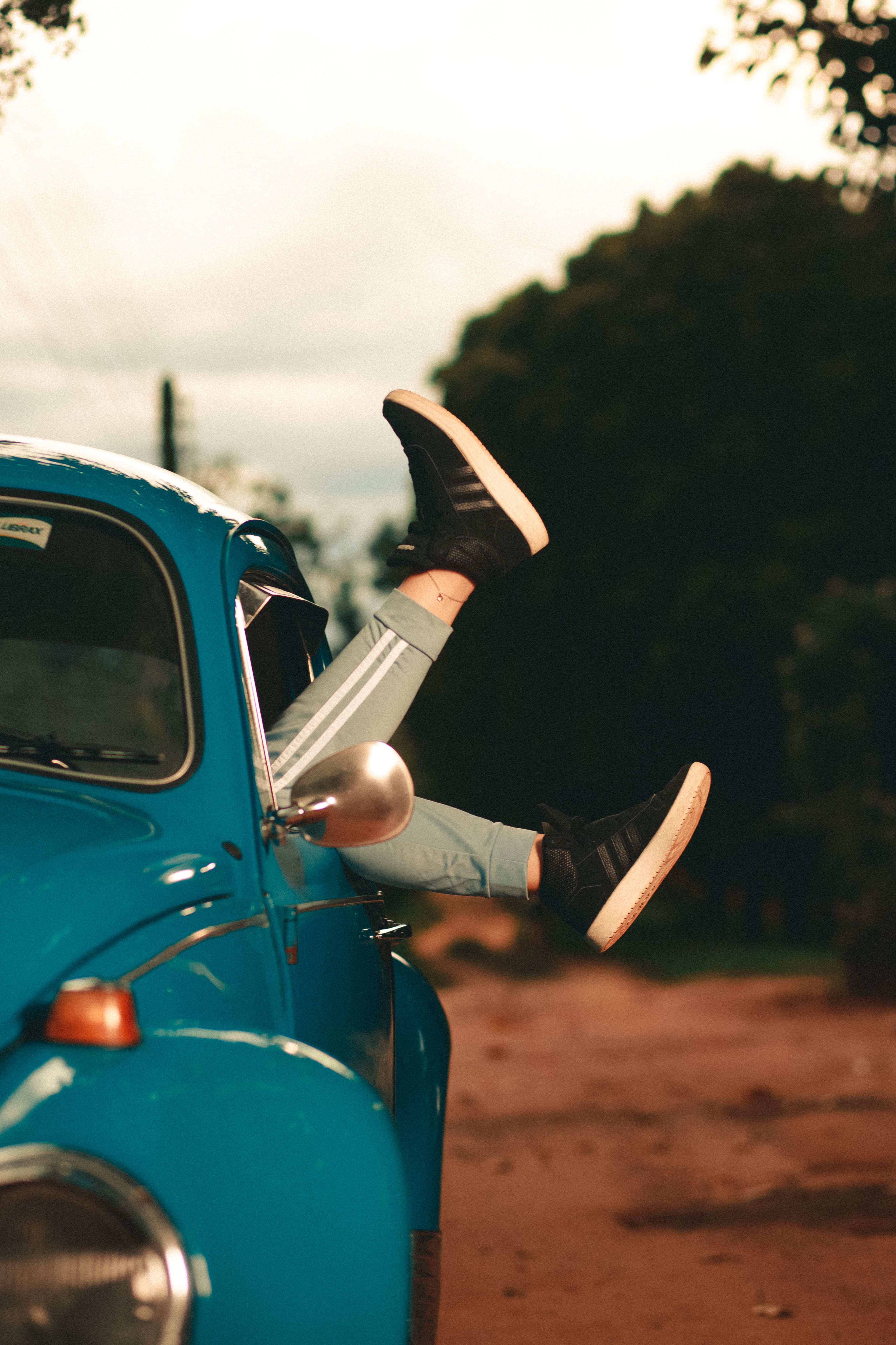 Legs of a Woman Sitting on a Truck with a Flat Tire · Free Stock Photo