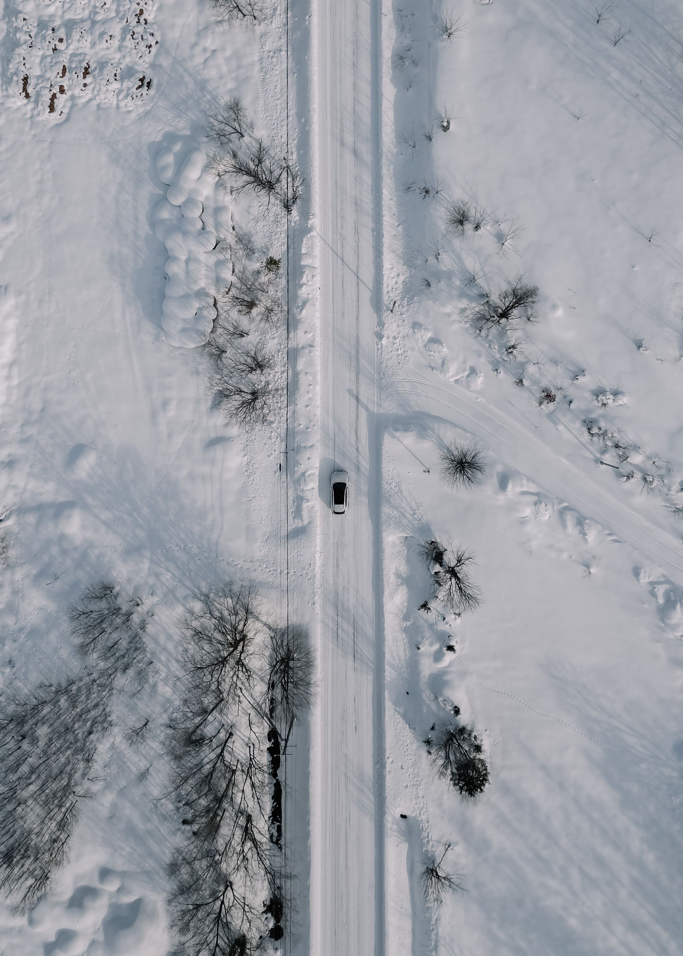 Aerial View of Car Driving along Snowy Road · Free Stock Photo