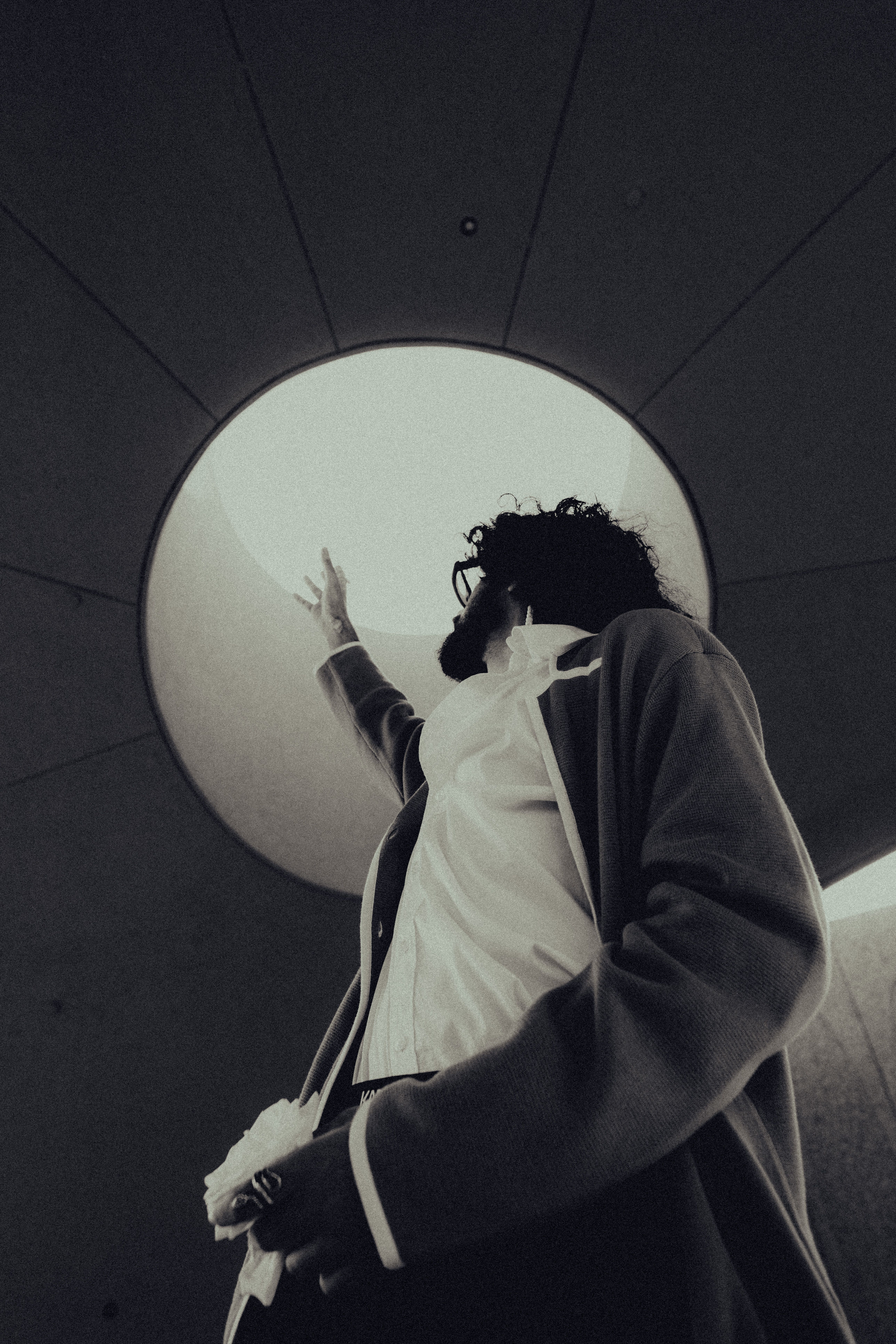 A man is standing in front of a circular light · Free Stock Photo