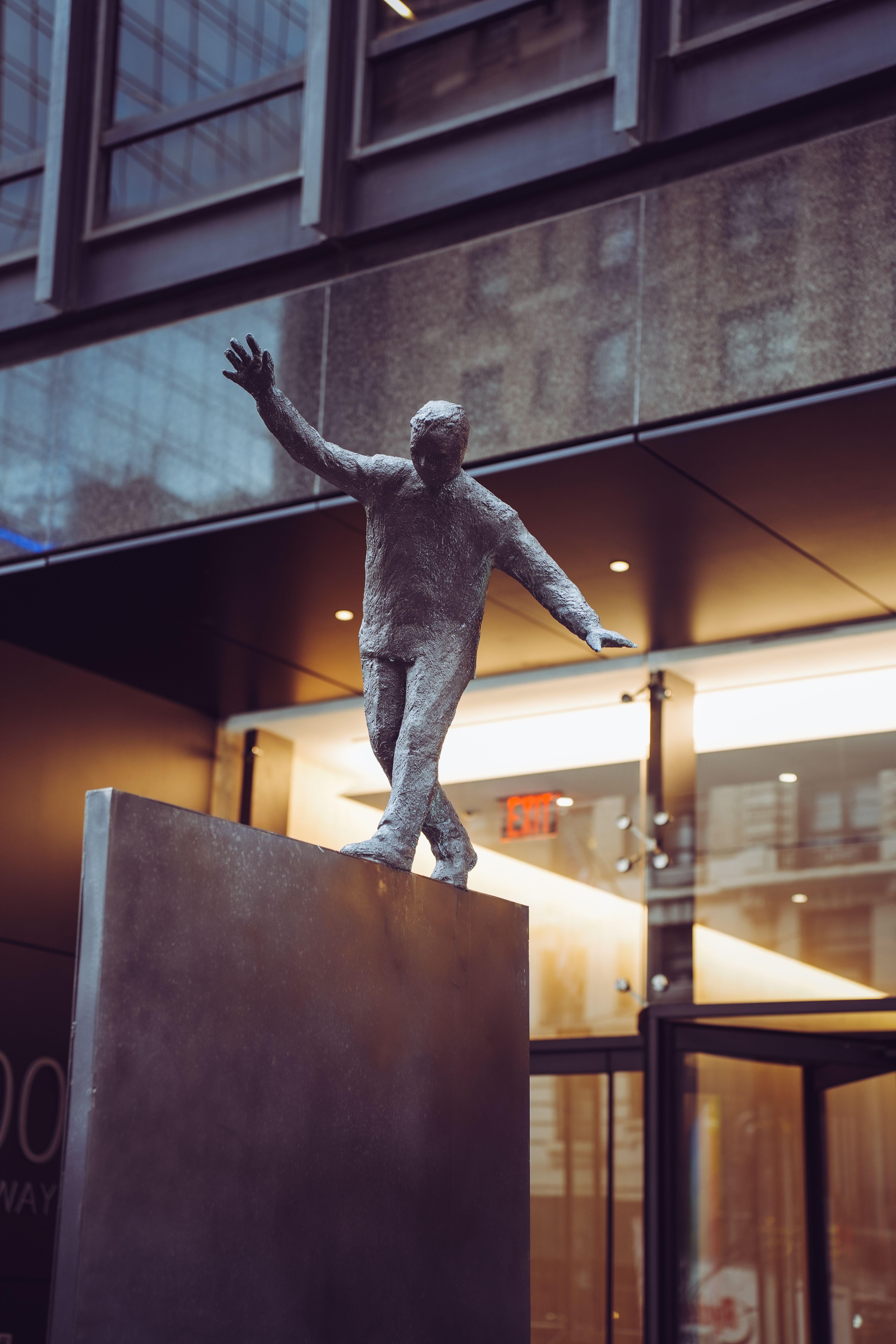Bronze Statue of Man Walking on Wall · Free Stock Photo