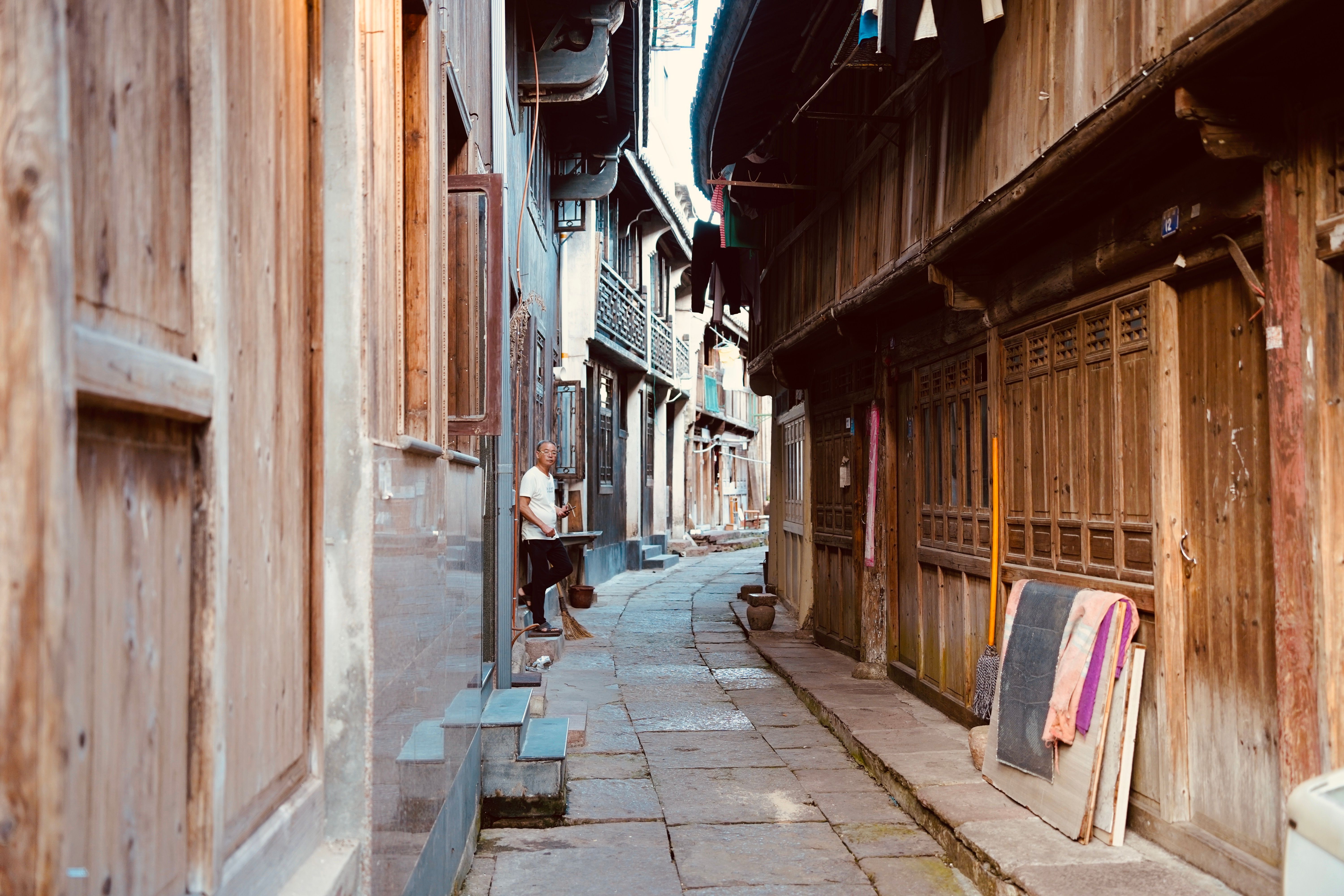 Narrow Paved Street with Traditional Wooden Buildings · Free Stock Photo
