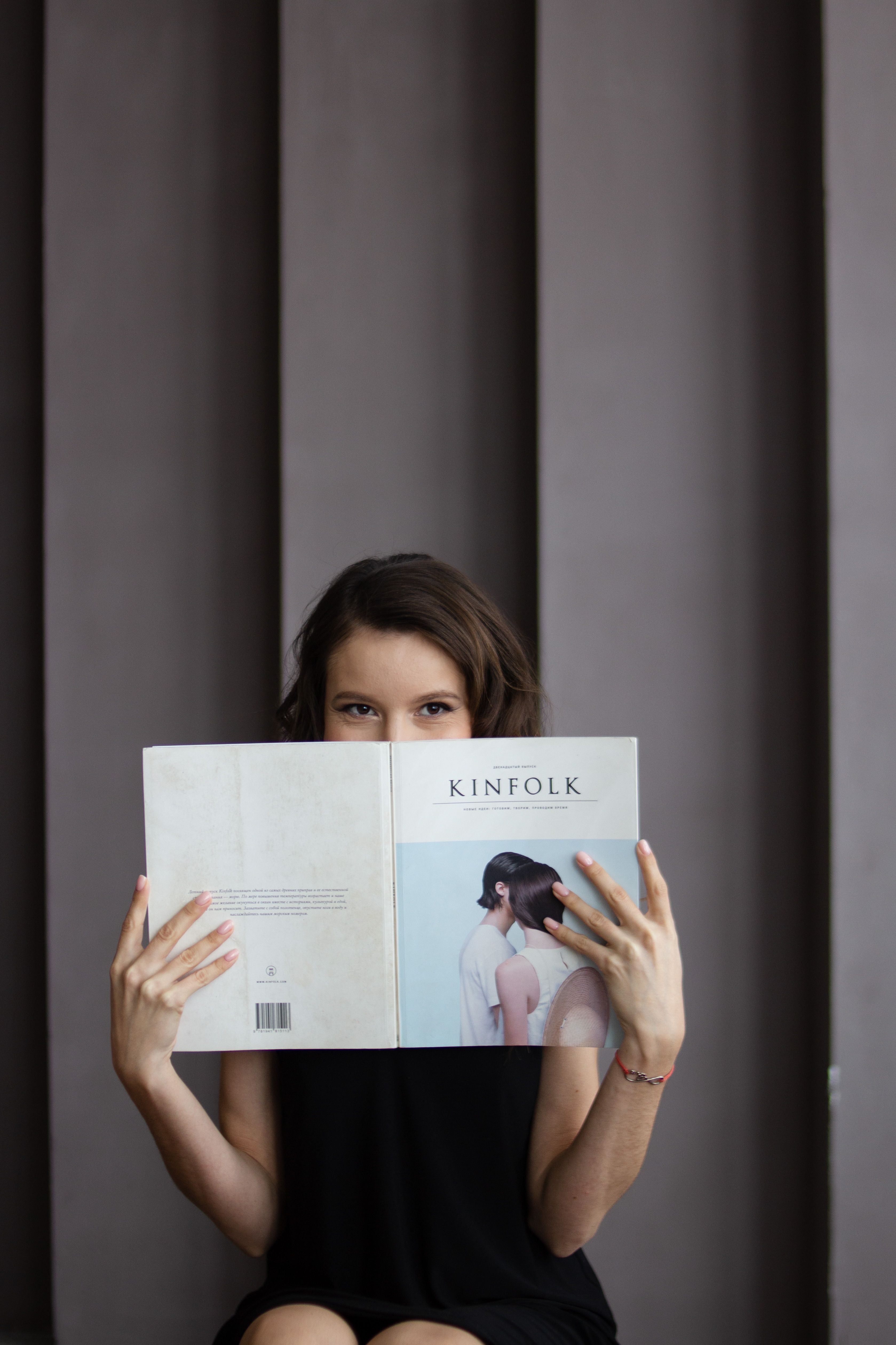 Woman Posing with Magazine on Grey Background · Free Stock Photo