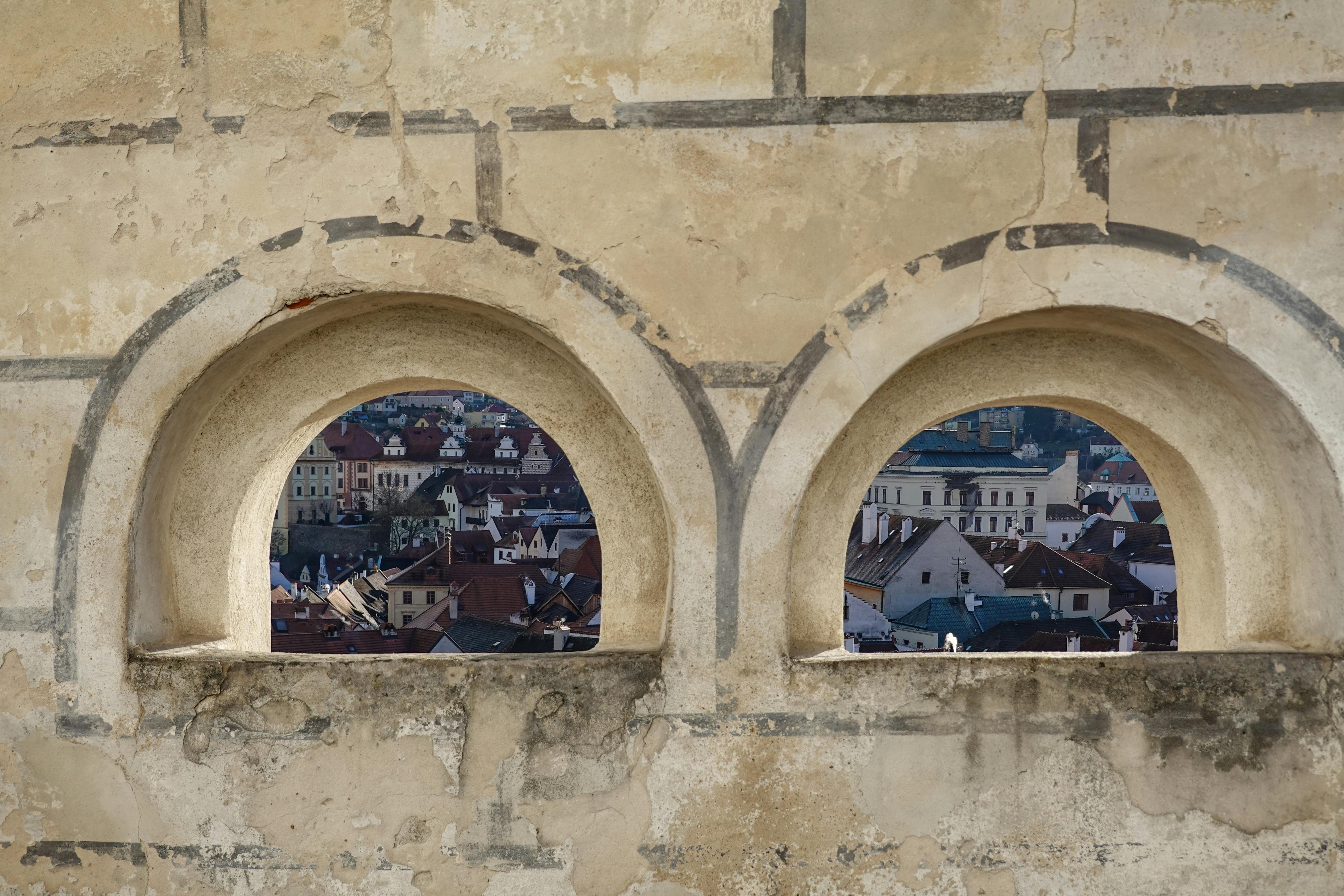 Two arched windows with a view of a city · Free Stock Photo