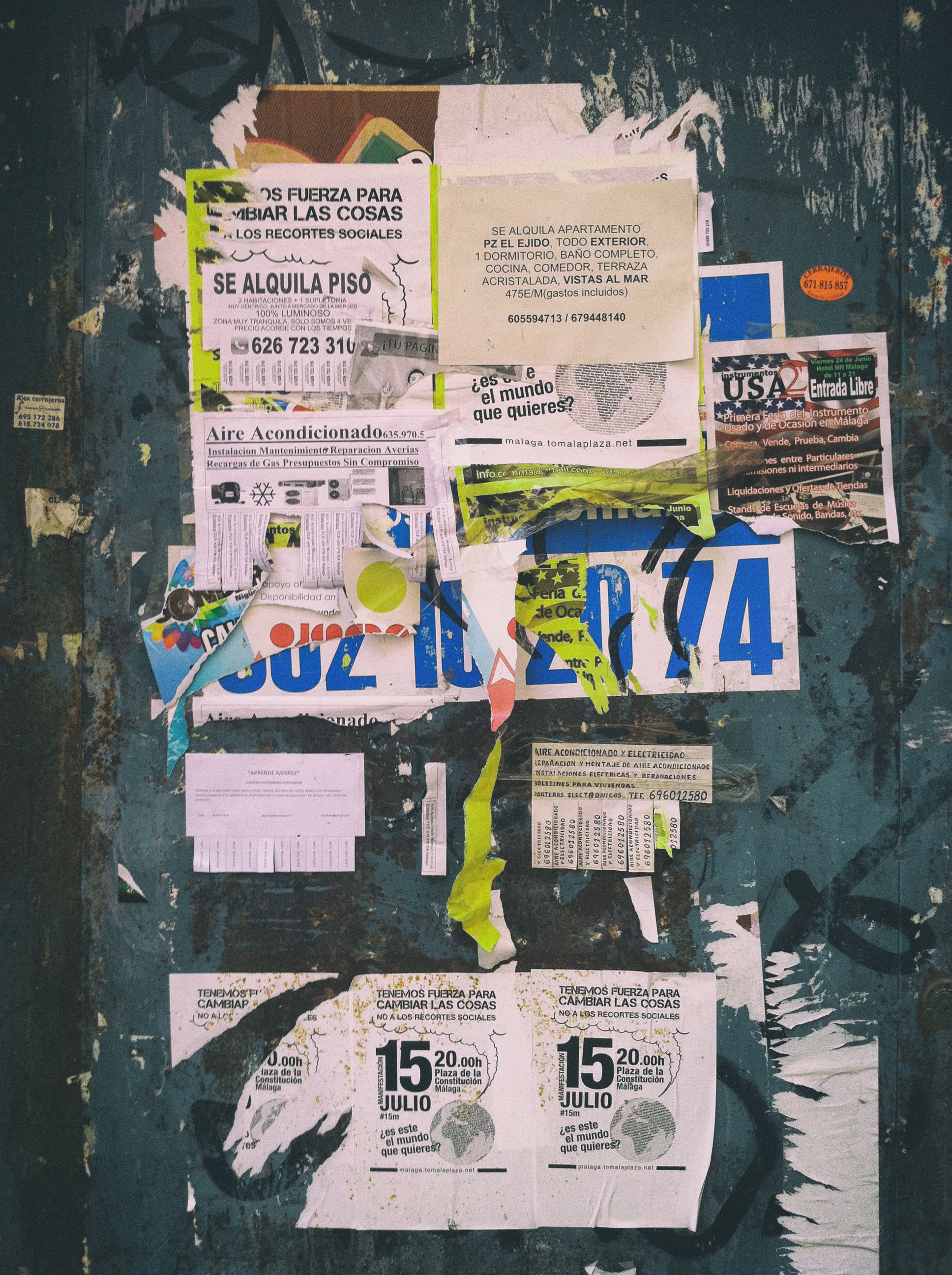 A collage of various posters and papers on a wall · Free Stock Photo