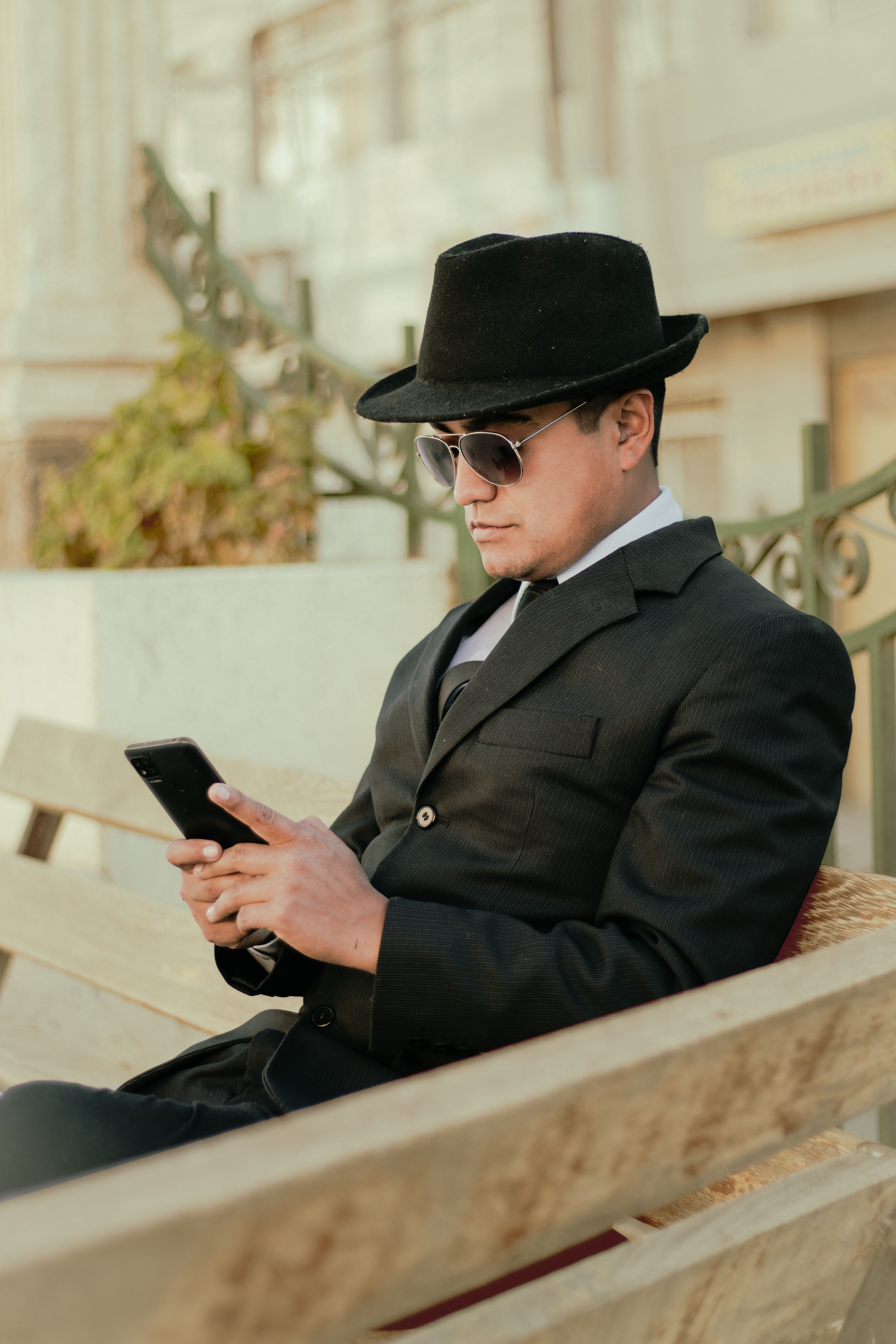 A man in a suit and hat is using a cell phone · Free Stock Photo