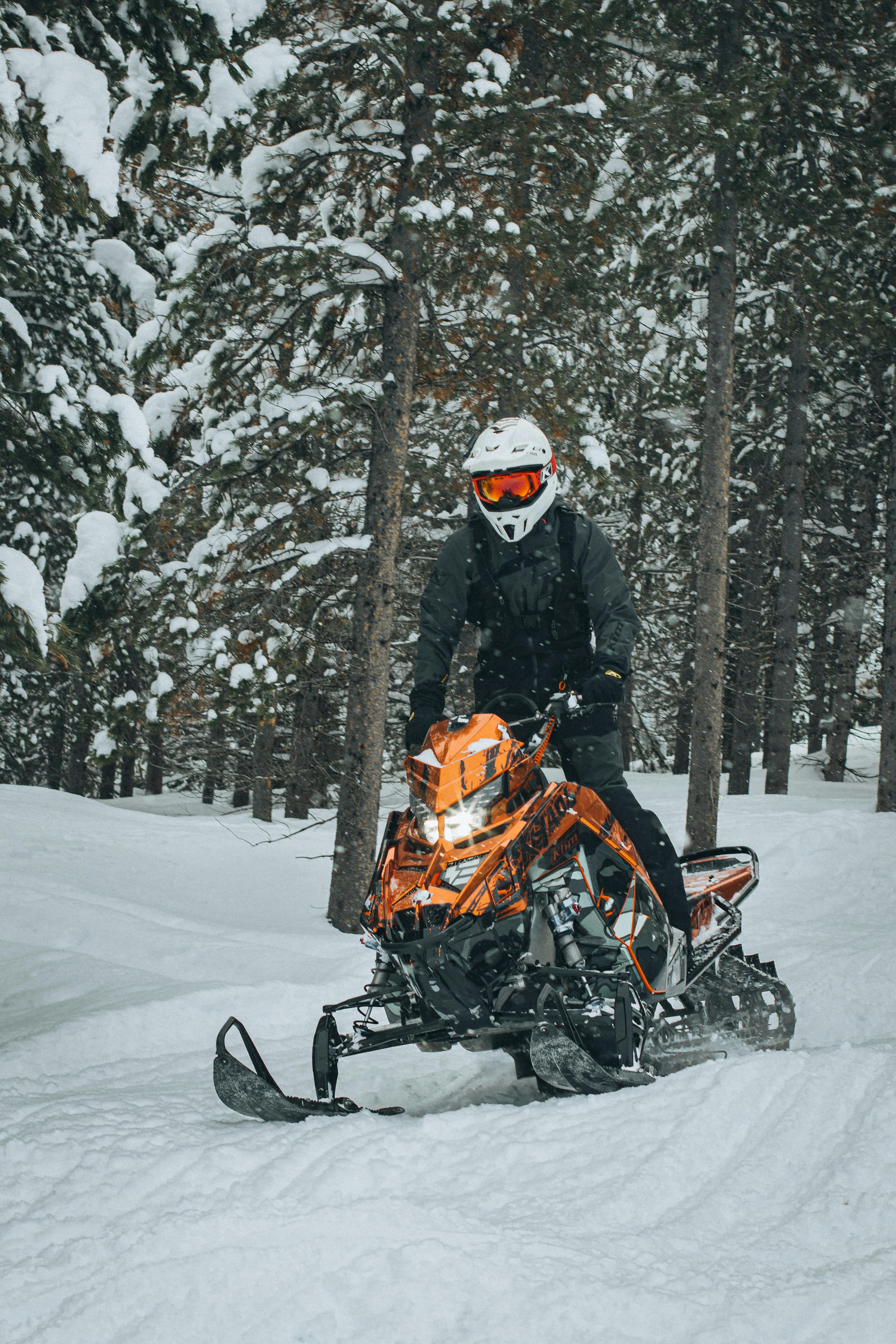 A Man in Black Jacket Riding a Snowmobile · Free Stock Photo