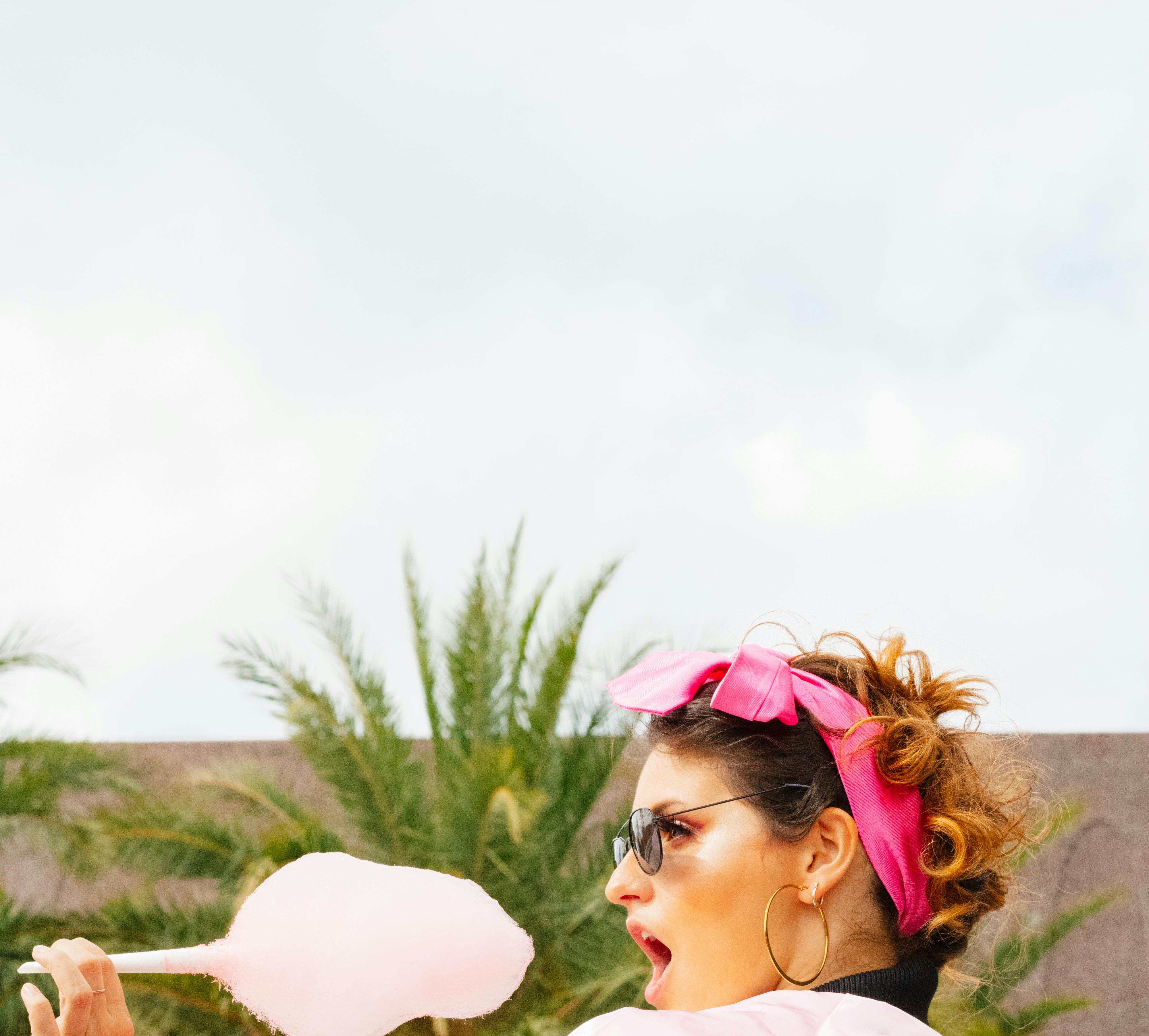 Woman in Green Crop Top Lace Eating Cotton Candy · Free Stock Photo