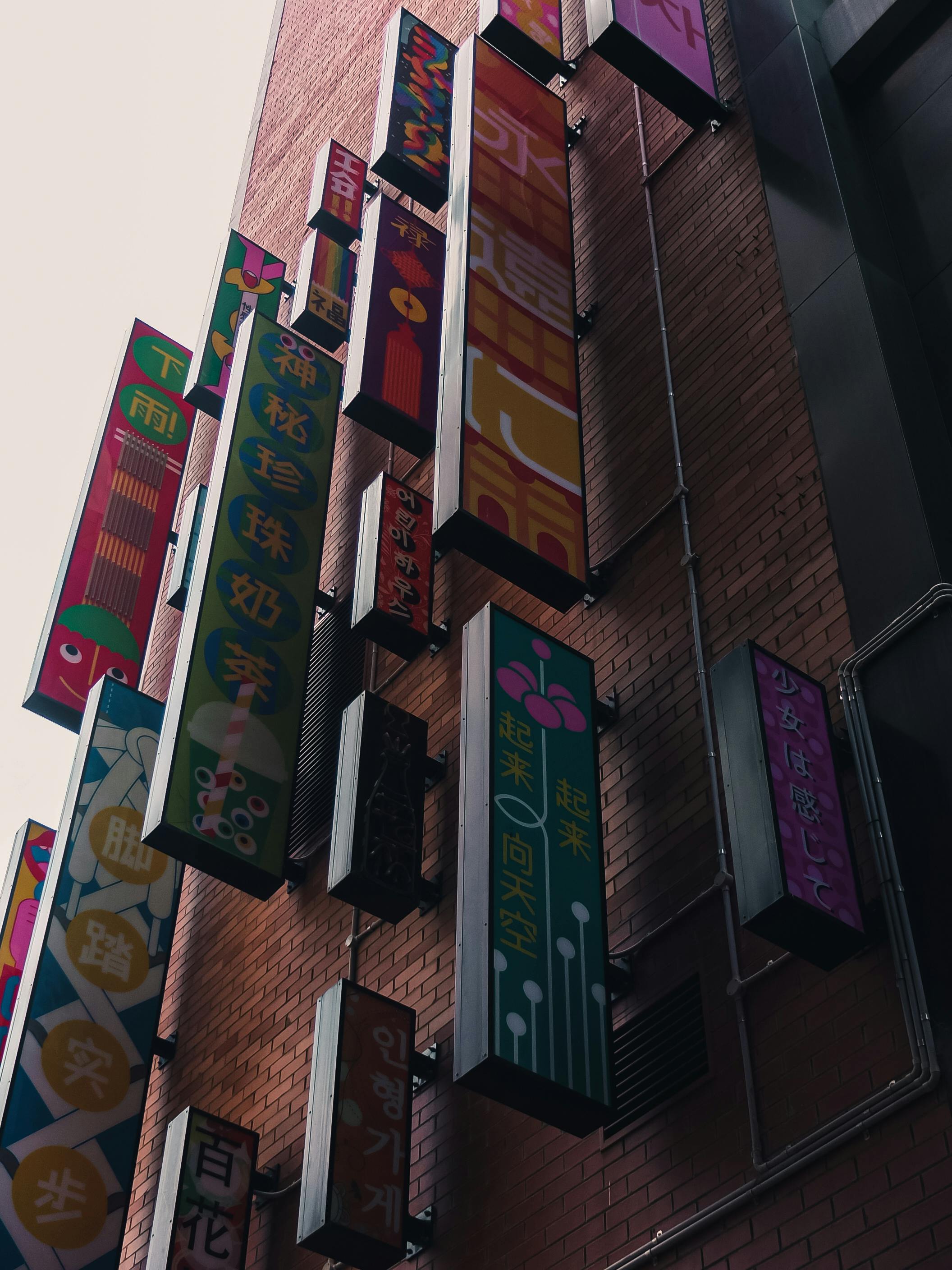 Colorful Signages on a Brick Wall · Free Stock Photo