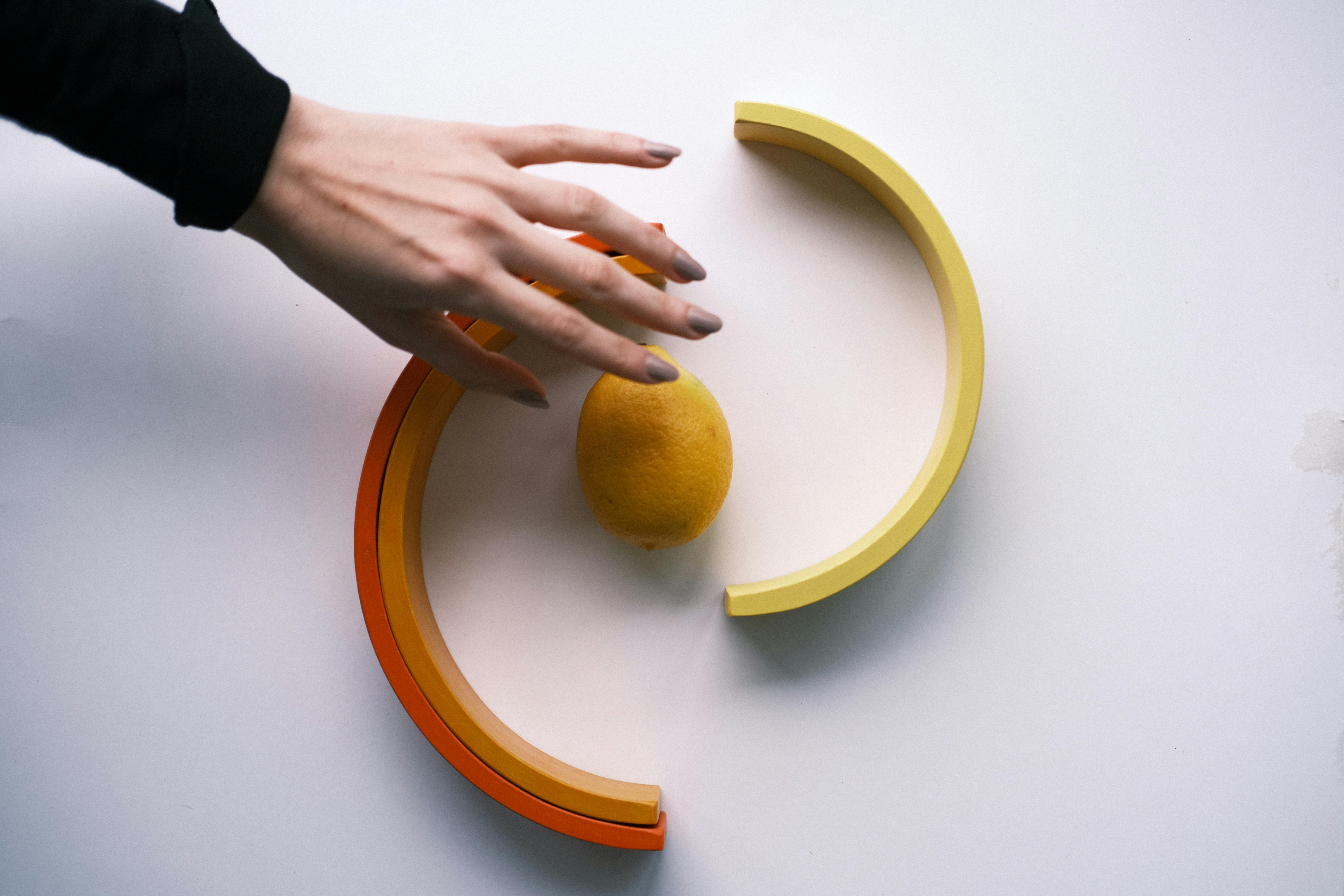 A Person Reaching for a Lemon Fruit · Free Stock Photo