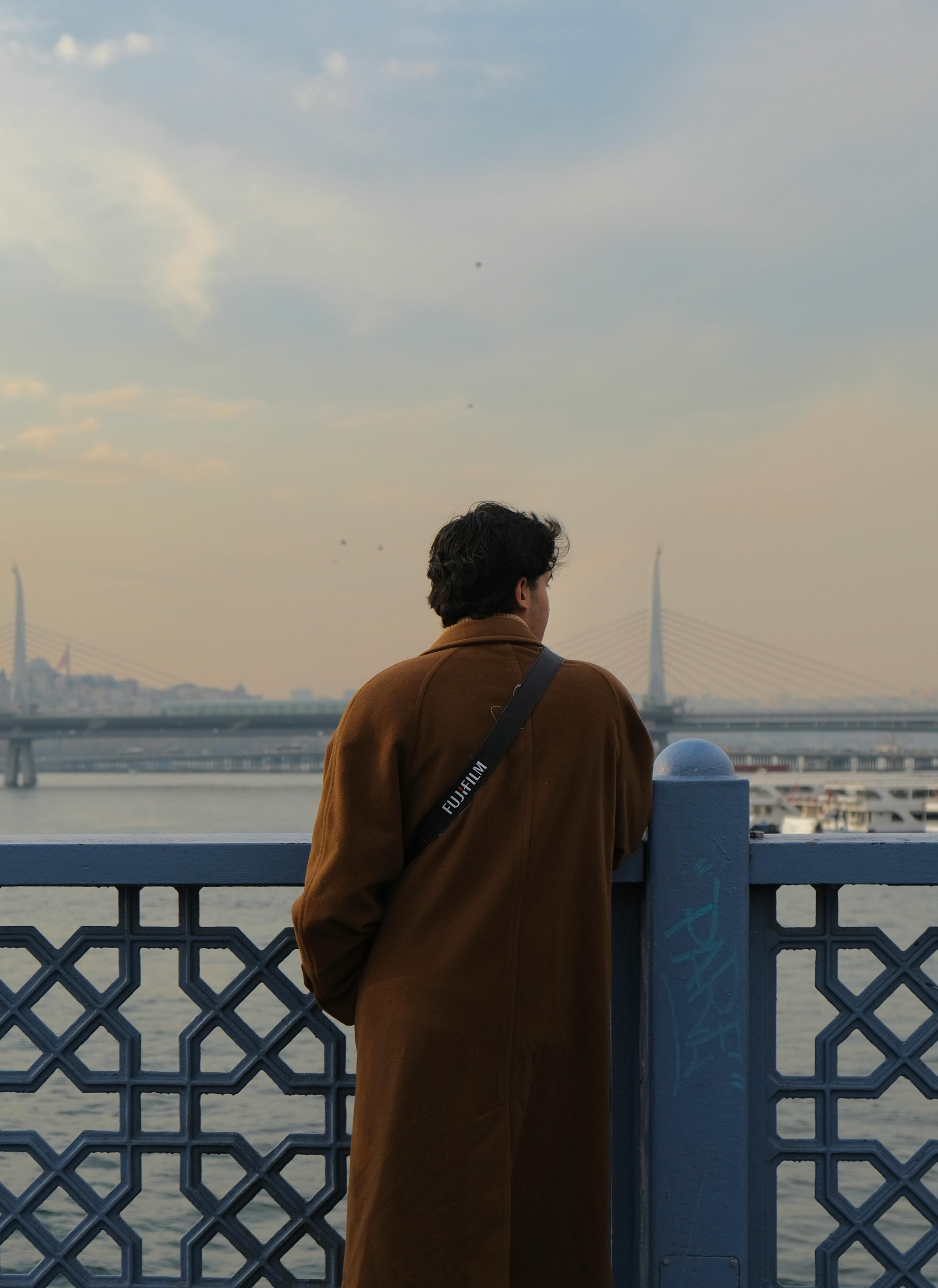 Back View of a Man in Brown Trench Coat Standing Near Railings · Free ...