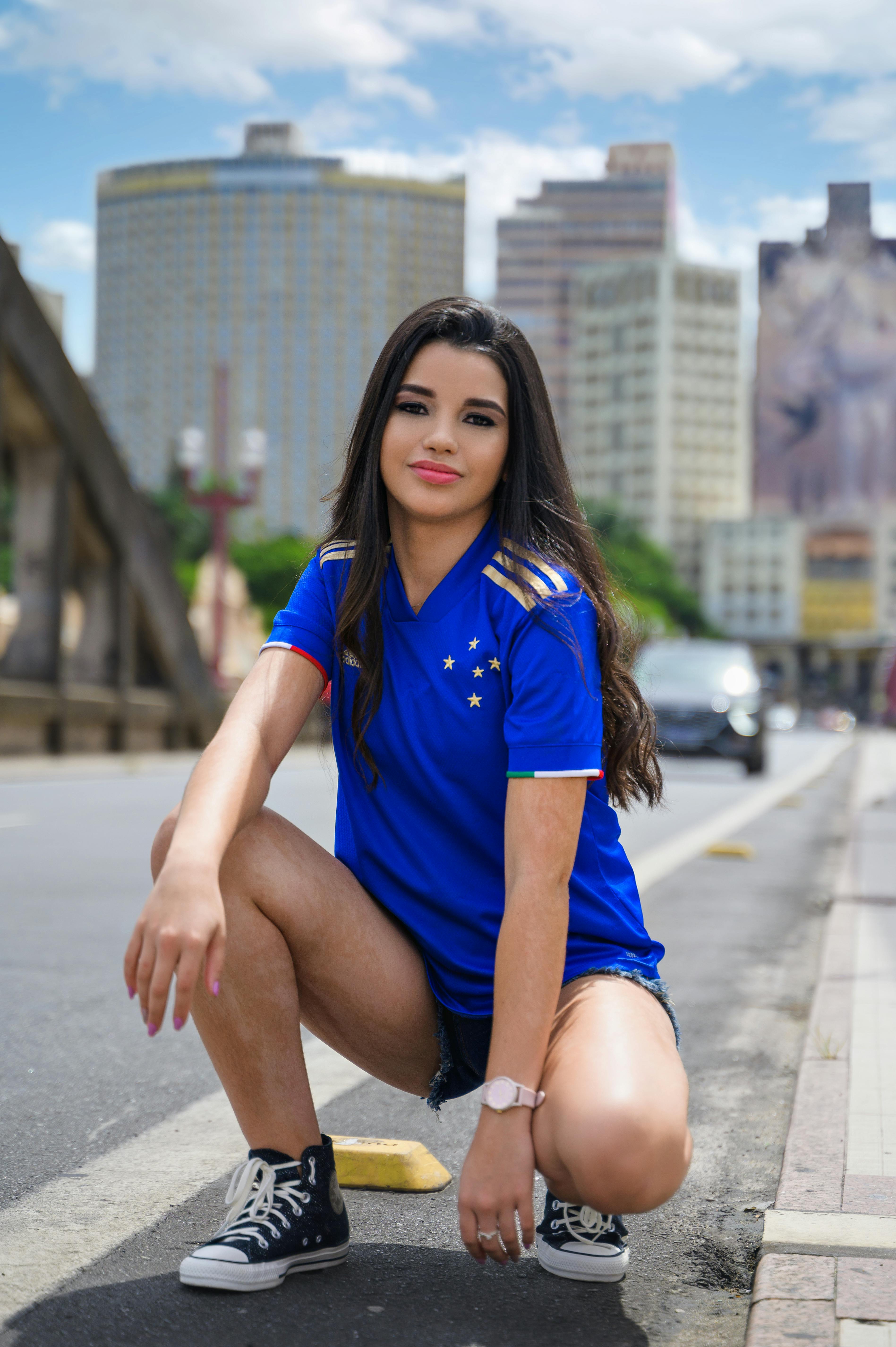 Girl in Football Uniform Posing on City Street · Free Stock Photo