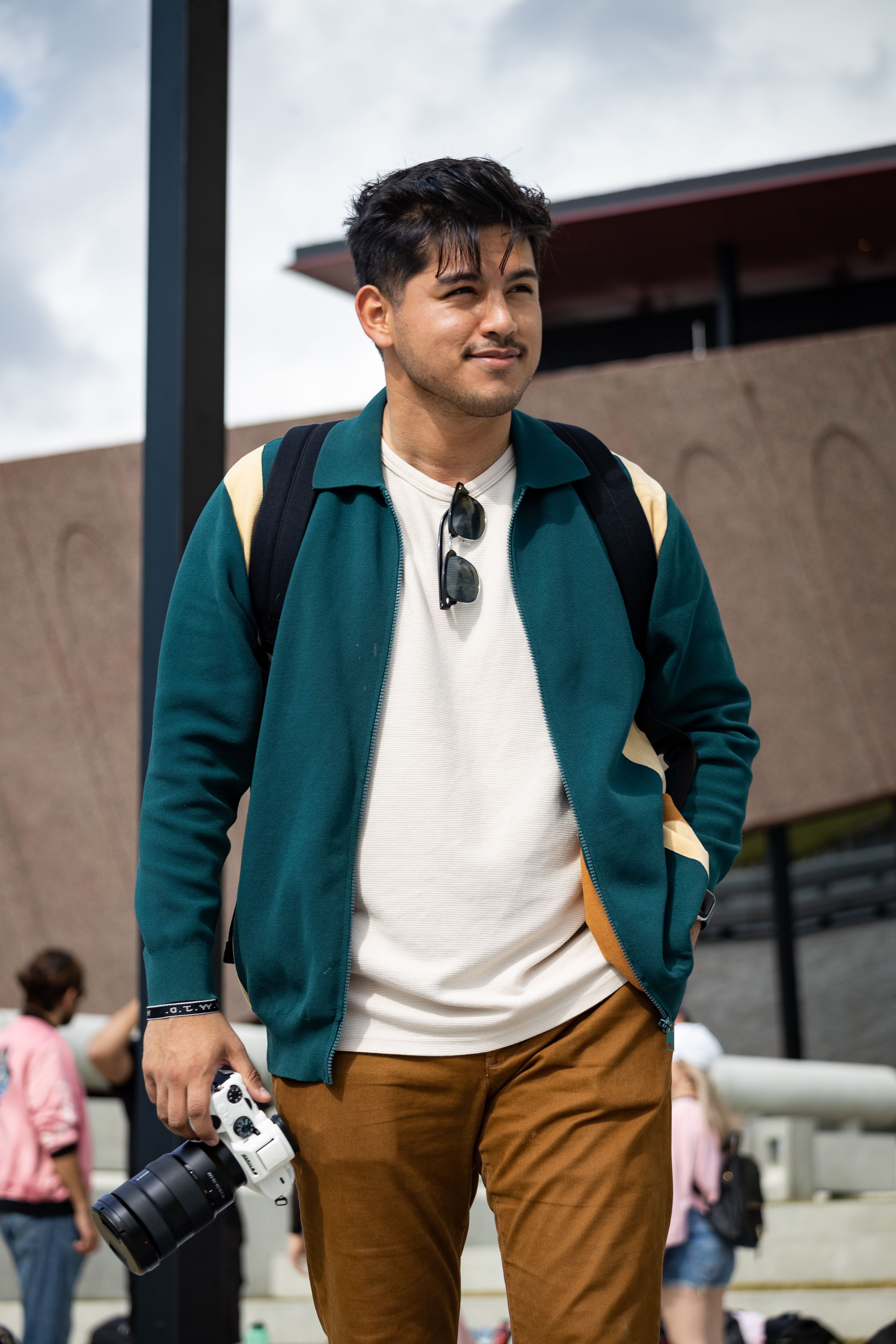 Pedestrian Walking with Camera in Hand · Free Stock Photo
