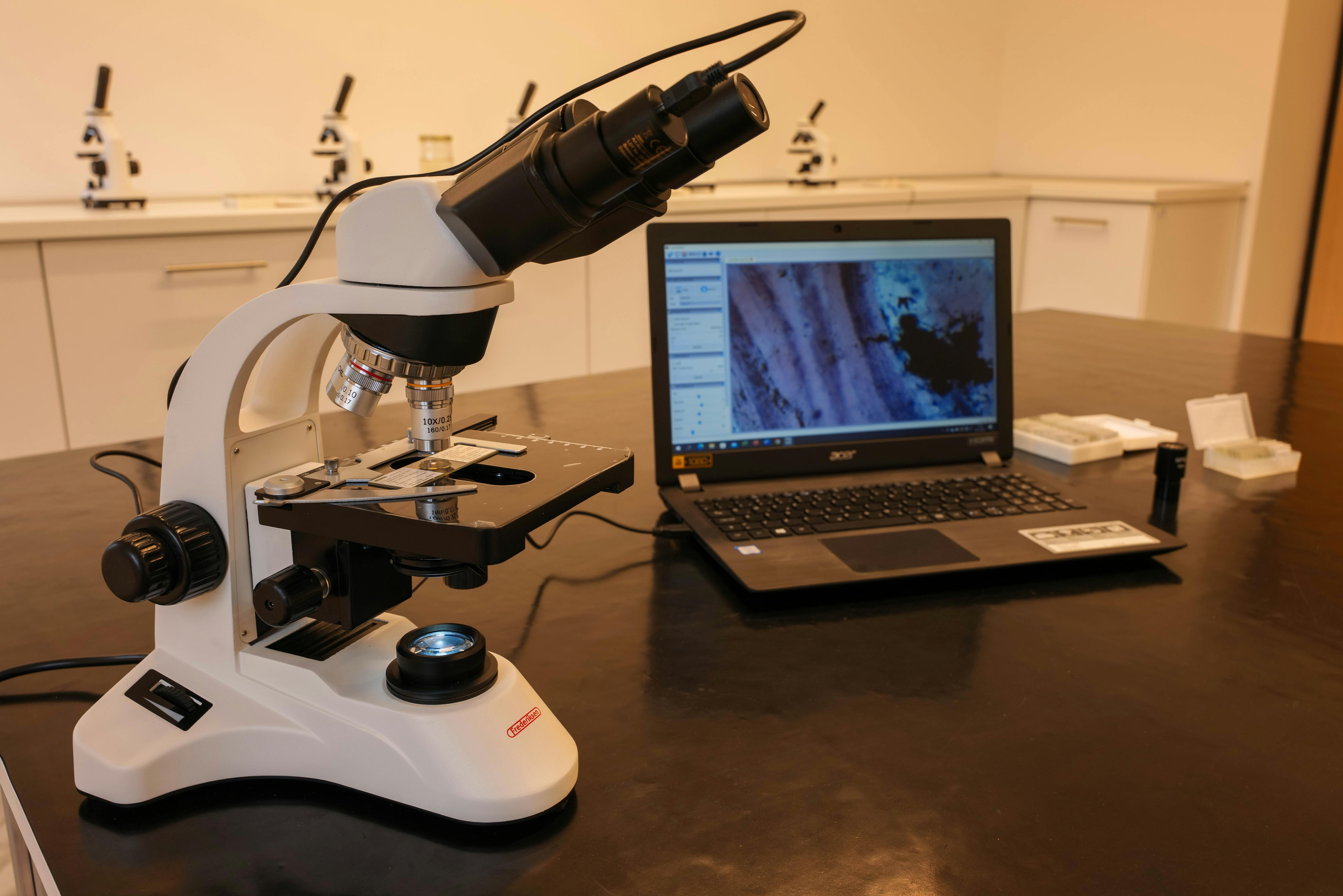 Close-Up Shot of Microscope and Laptop on Black Surface · Free Stock Photo