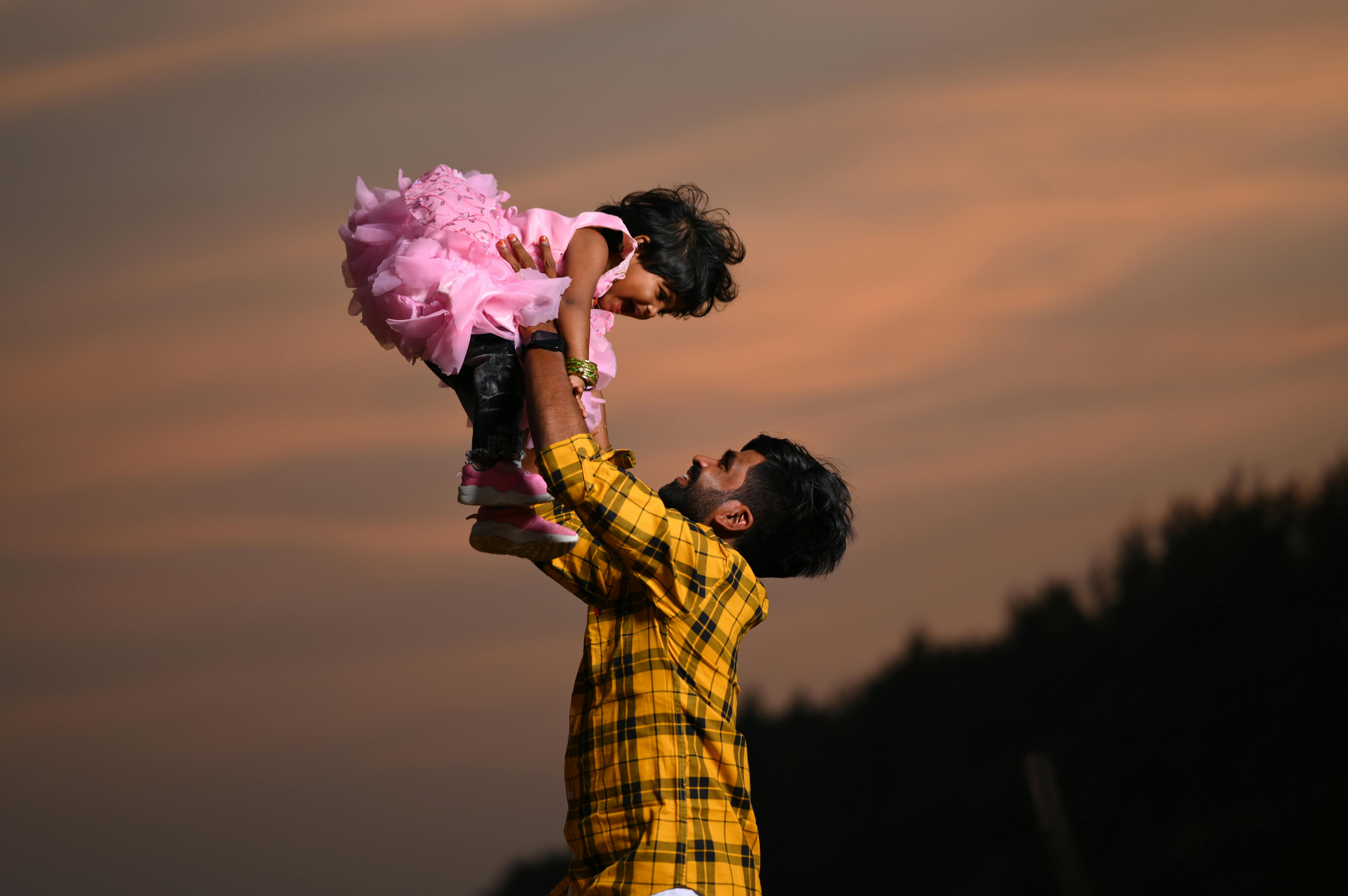 Smiling Father Raising Daughter · Free Stock Photo