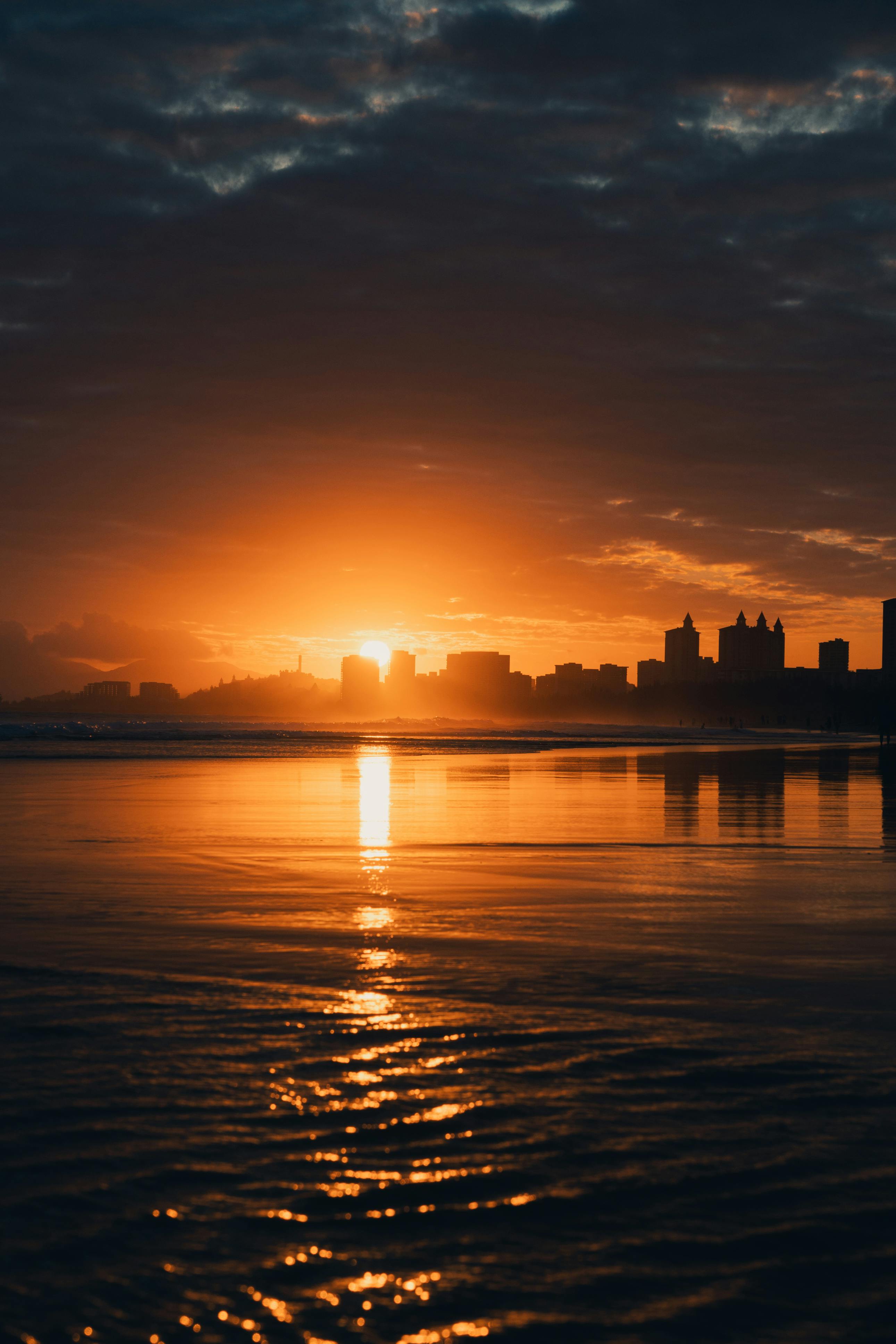 Sunlight over Coast with City behind · Free Stock Photo