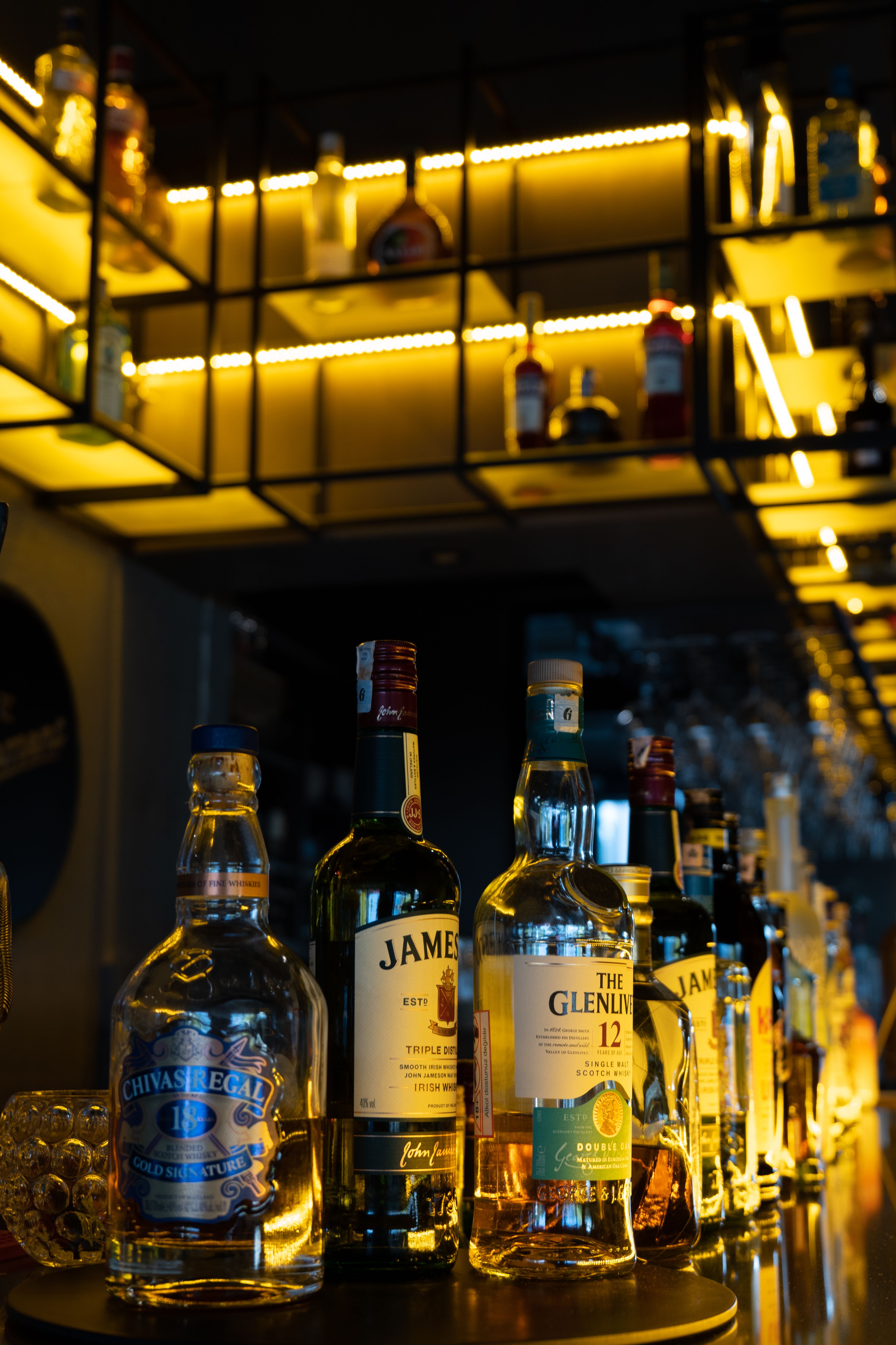 A bar with bottles of alcohol on the shelves · Free Stock Photo